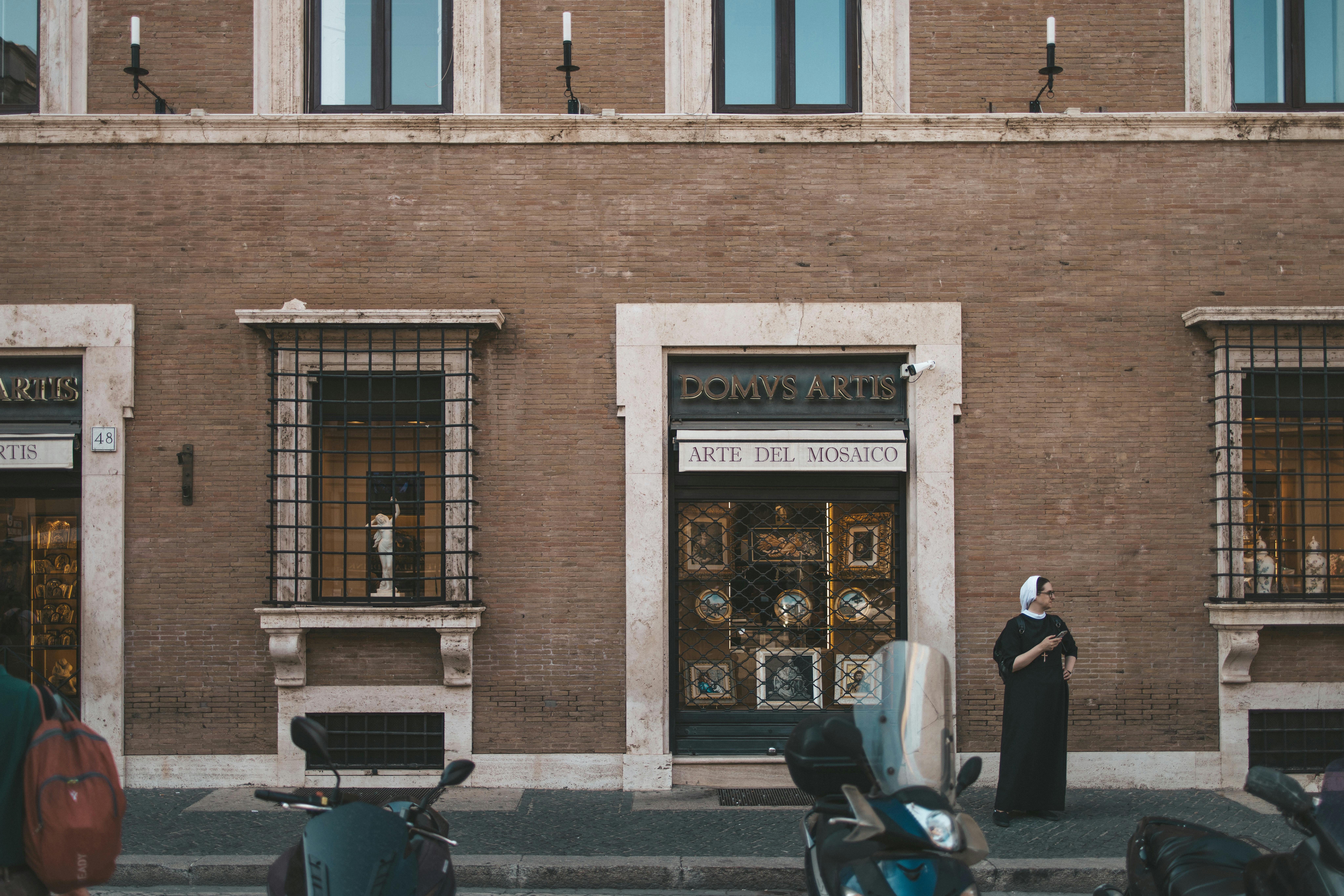 Nun Standing on Sidewalk by Building in Vatican City · Free Stock Photo