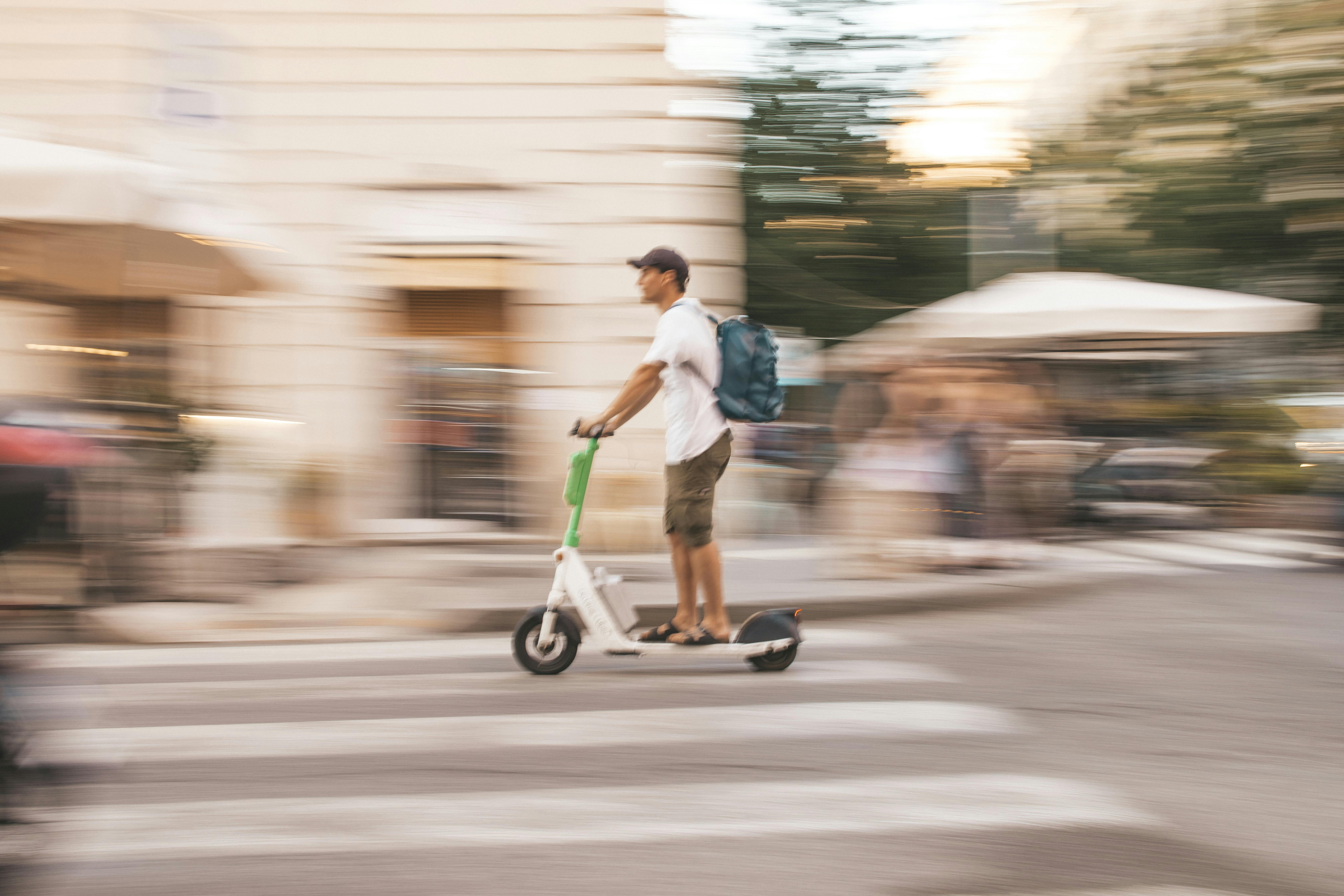 Man Riding on Electric Scooter on Street in City · Free Stock Photo