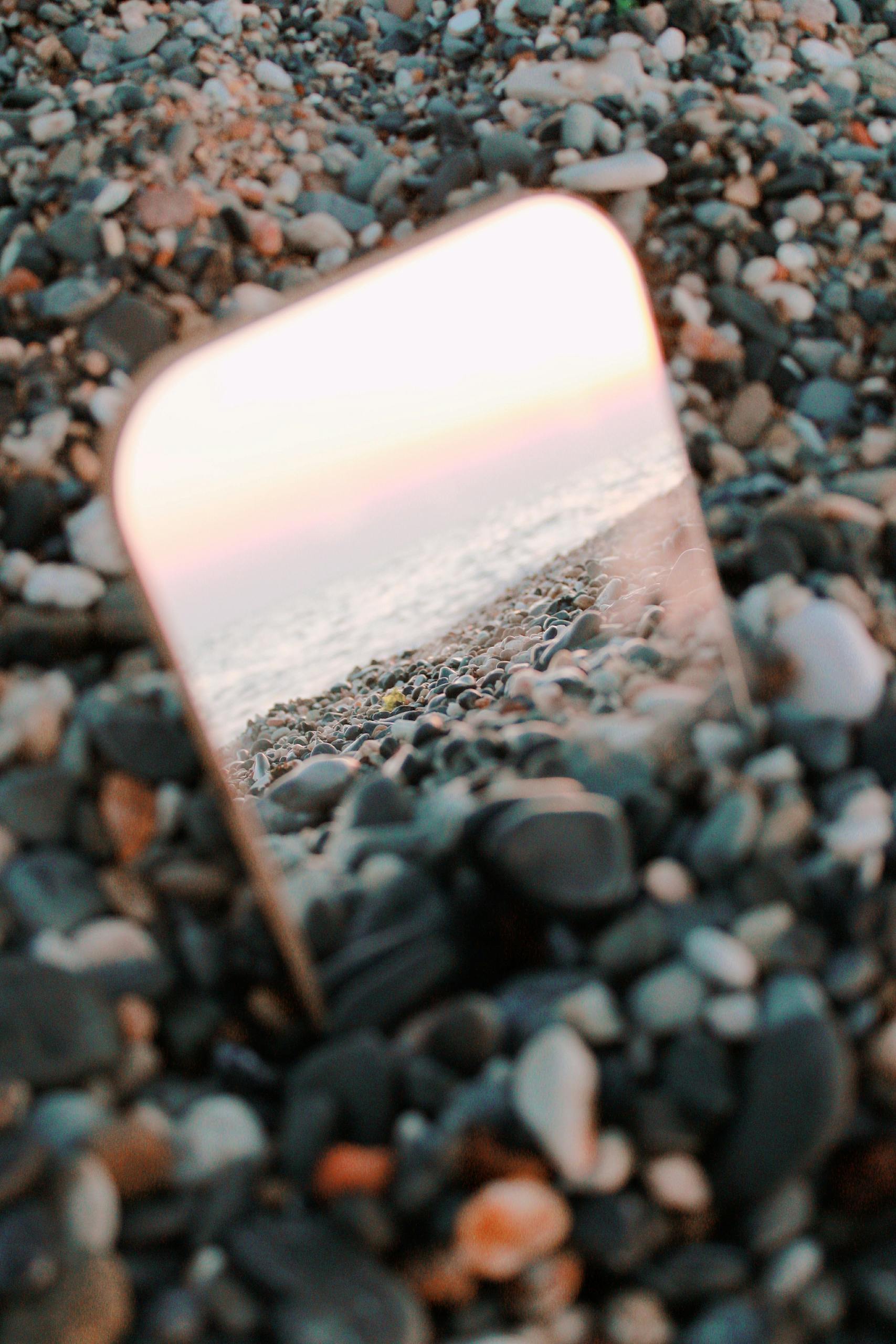 Mirror on Pebbles on Shore at Sunset · Free Stock Photo