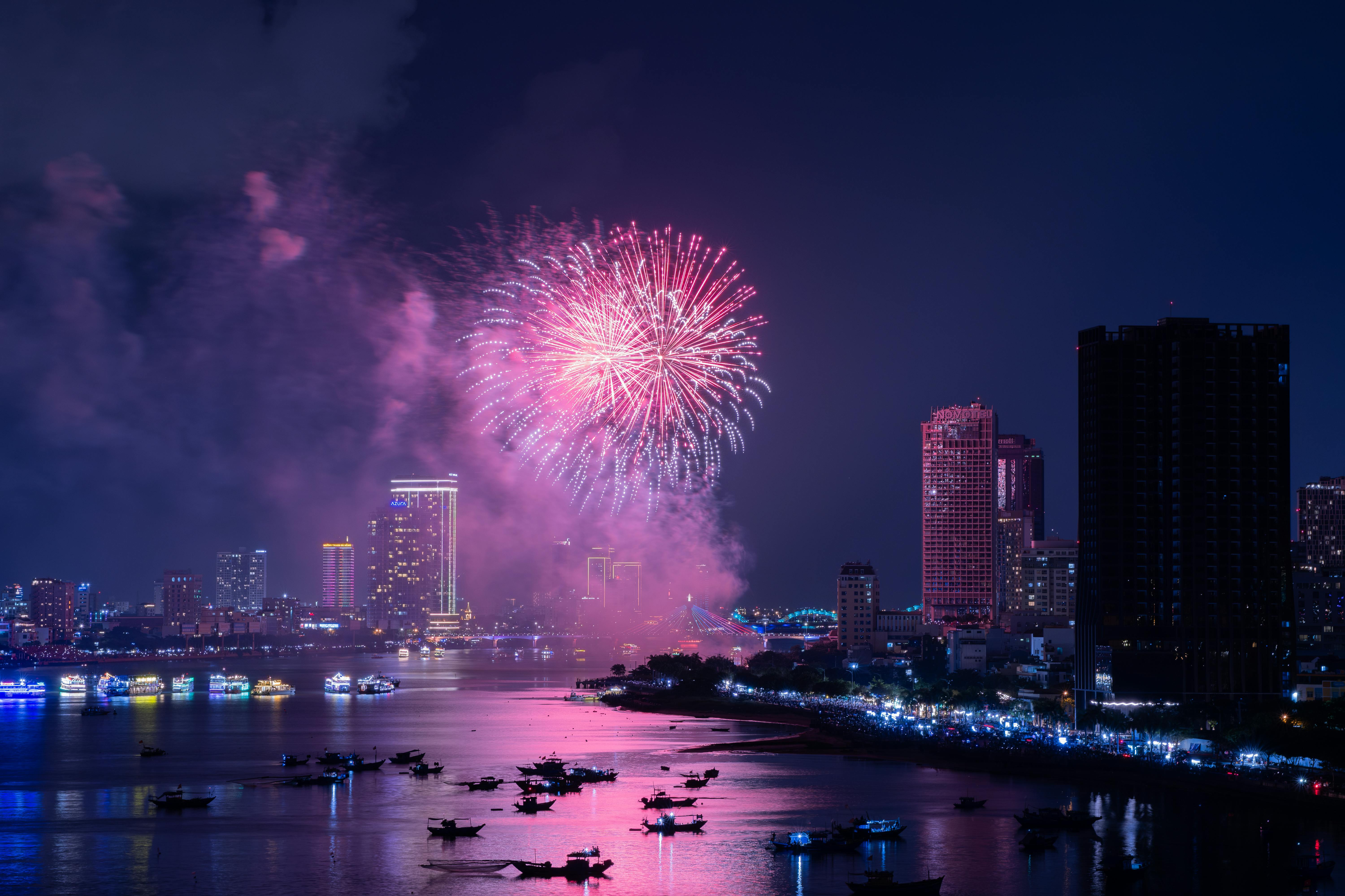 Fireworks over the water in a city at night · Free Stock Photo