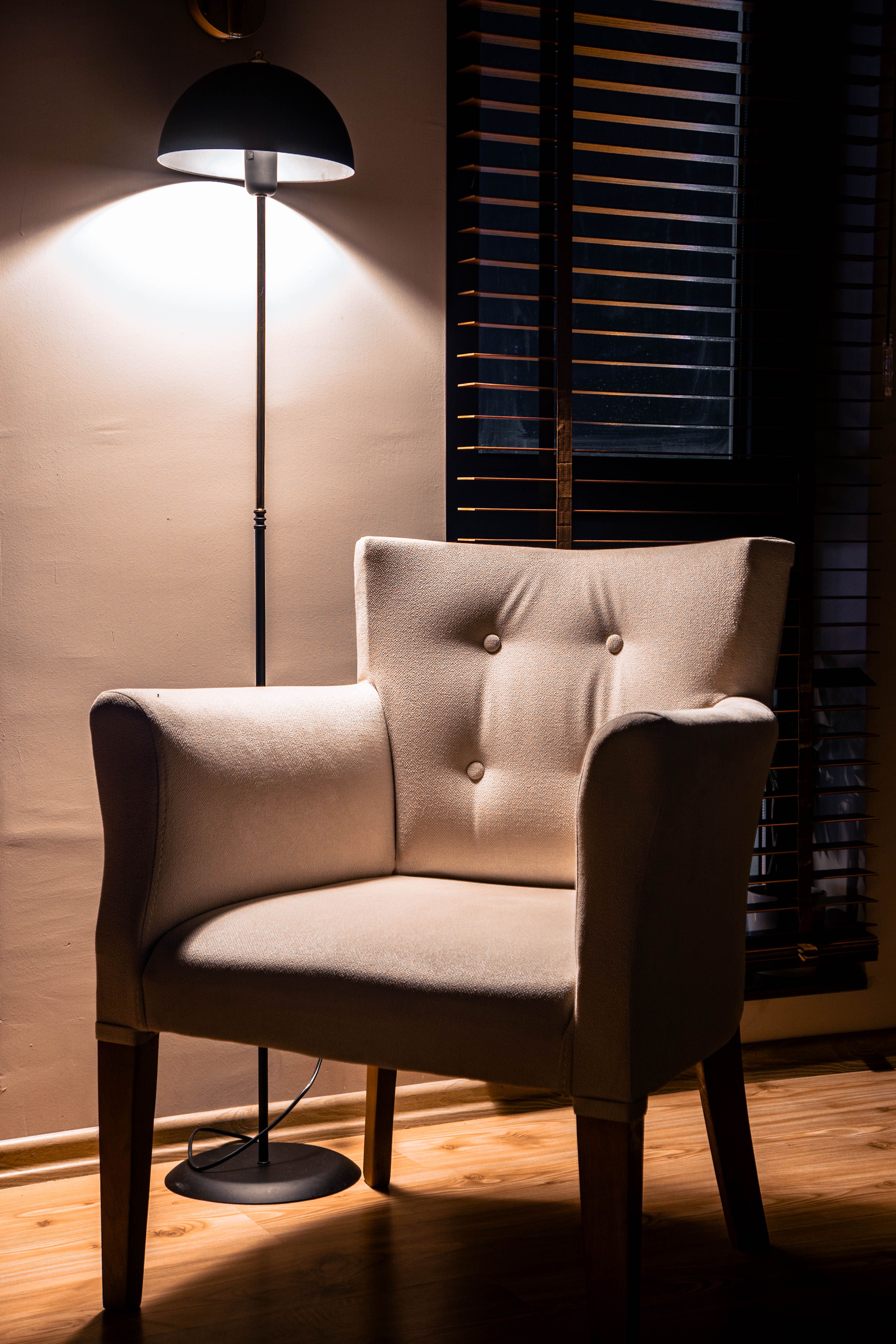 White Armchair Illuminated by a Floor Lamp · Free Stock Photo