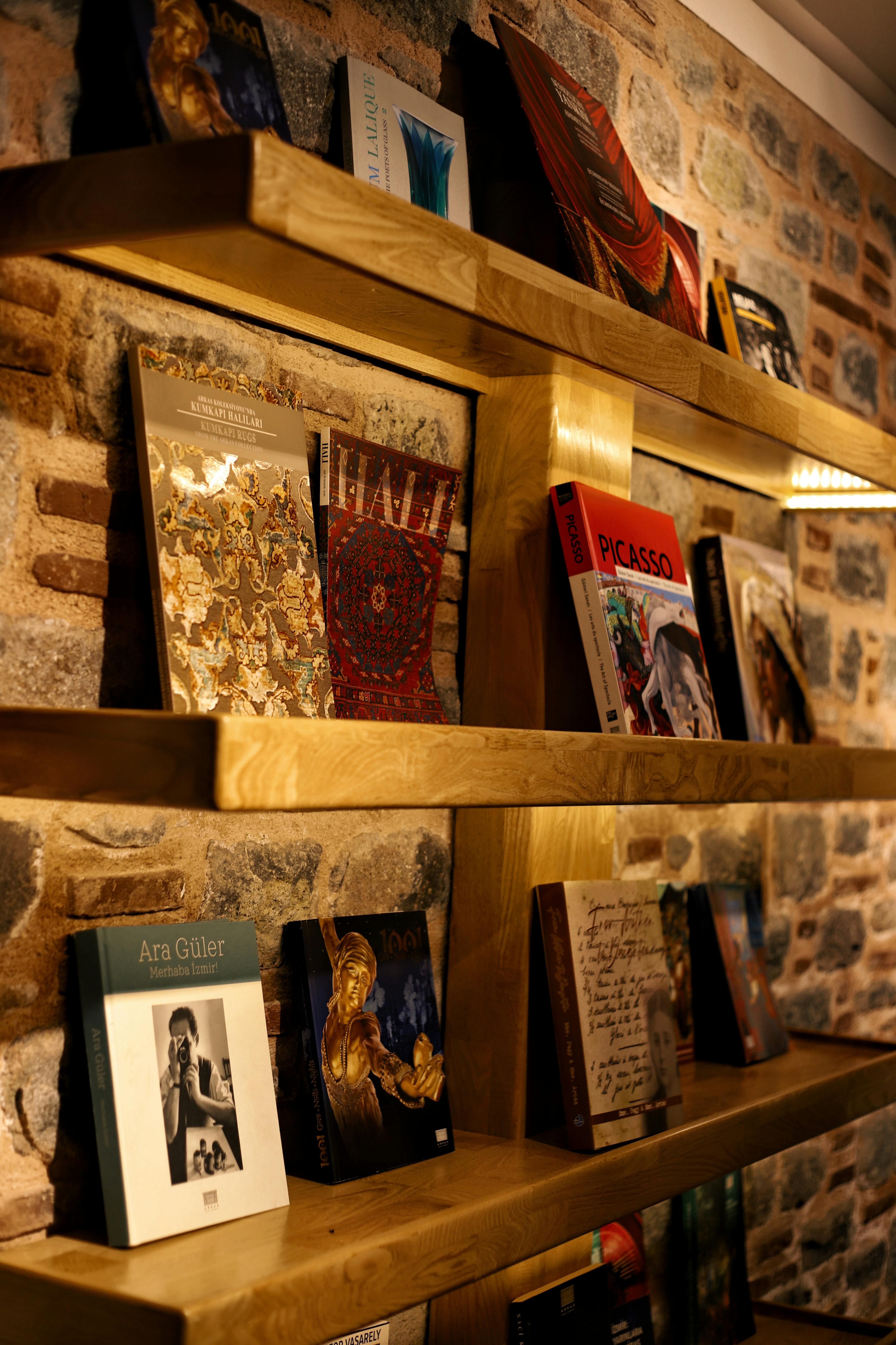 Close-up of a Shelf with Books Hanging on a Brick Wall · Free Stock Photo