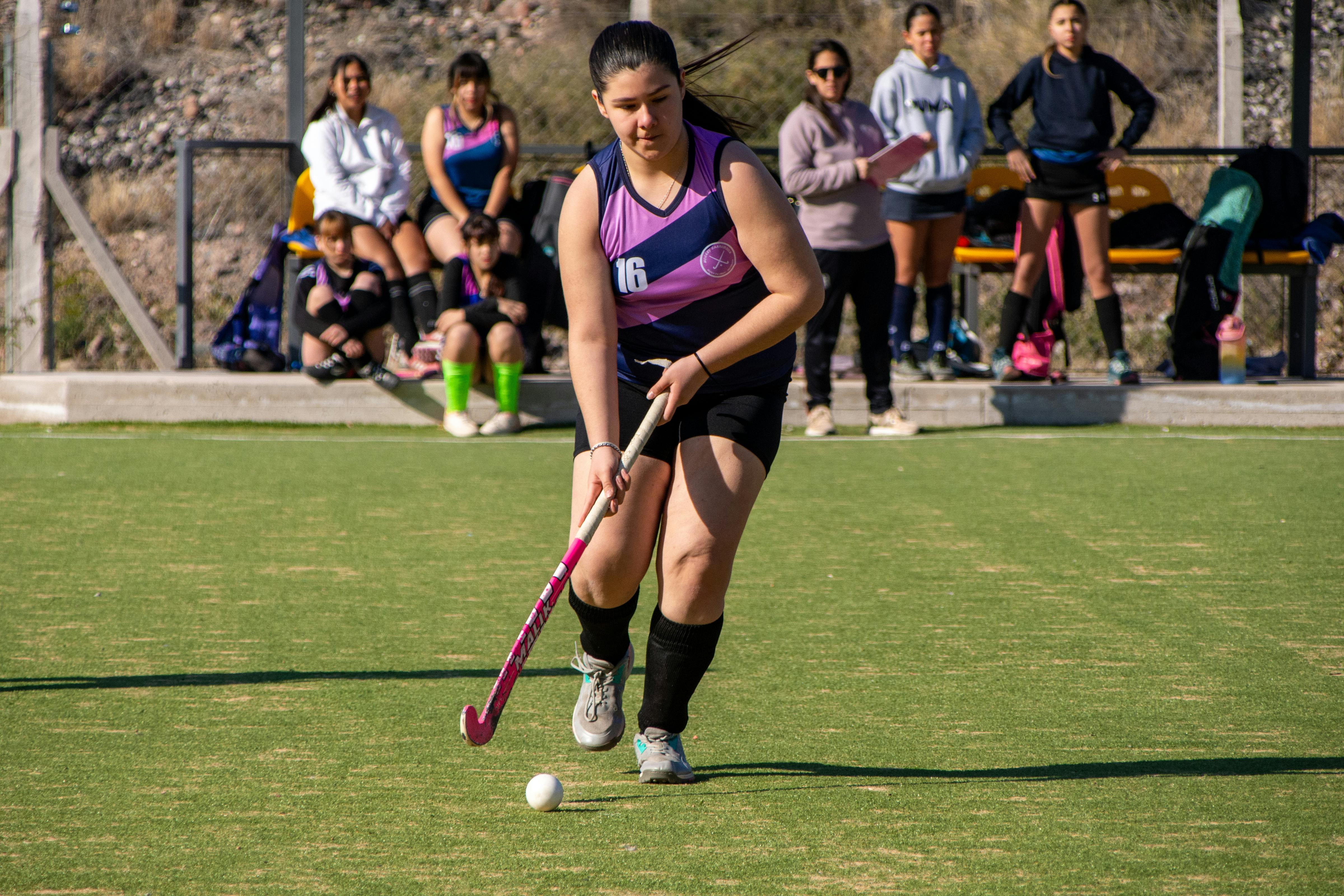 A woman in purple and black playing field hockey · Free Stock Photo