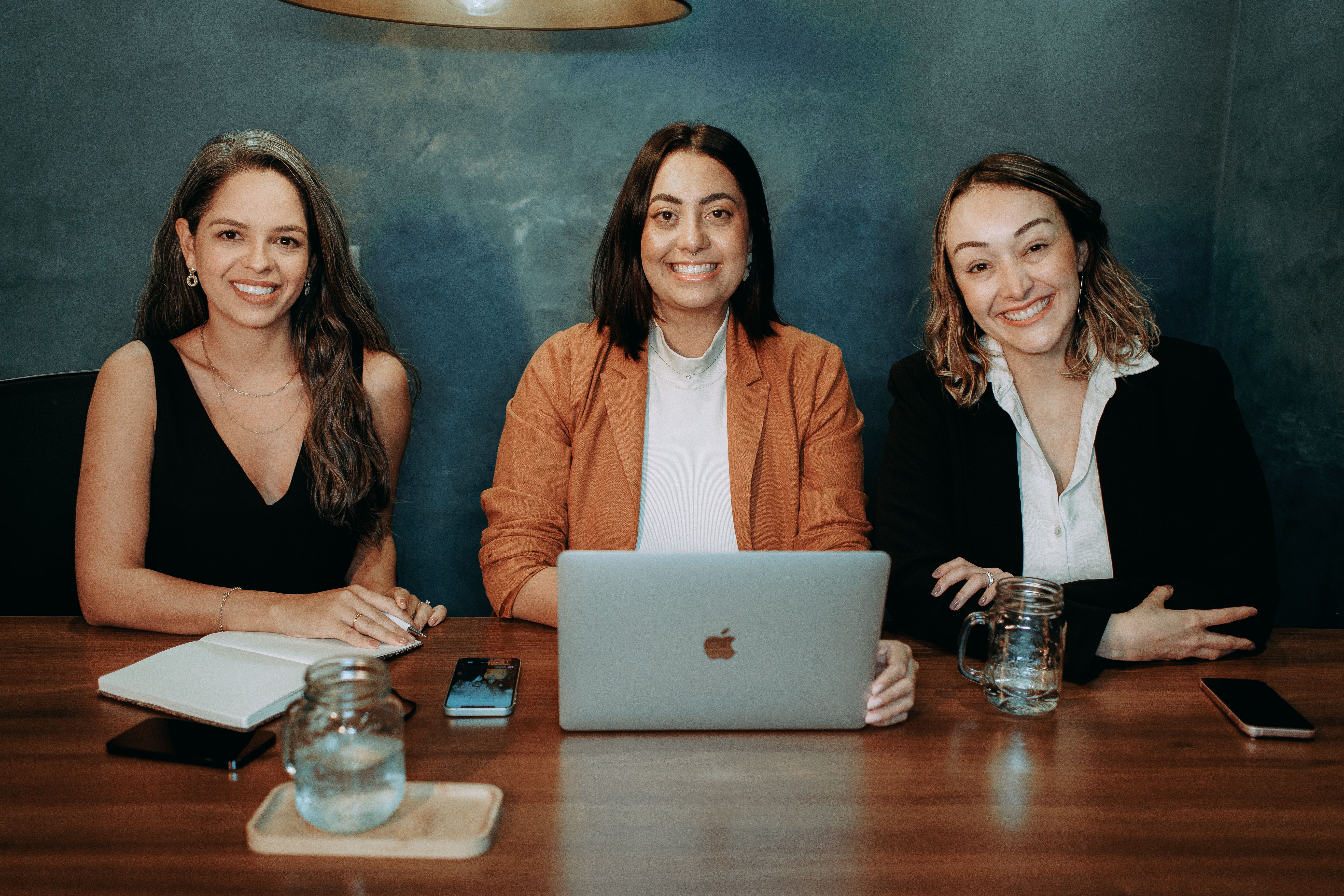 Three Women Collaborating at a Desk · Free Stock Photo