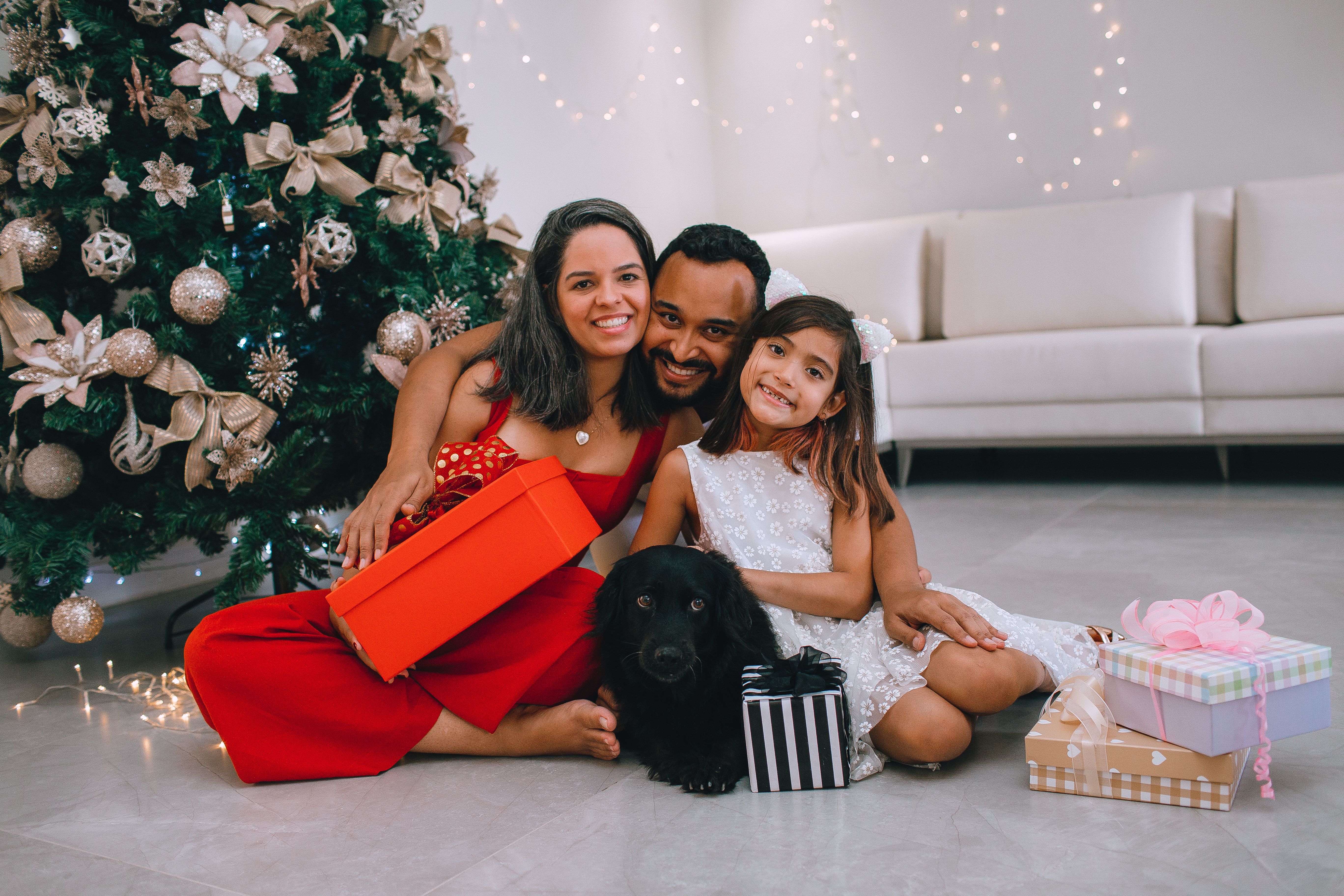 A family poses for a photo with gifts under a christmas tree · Free ...