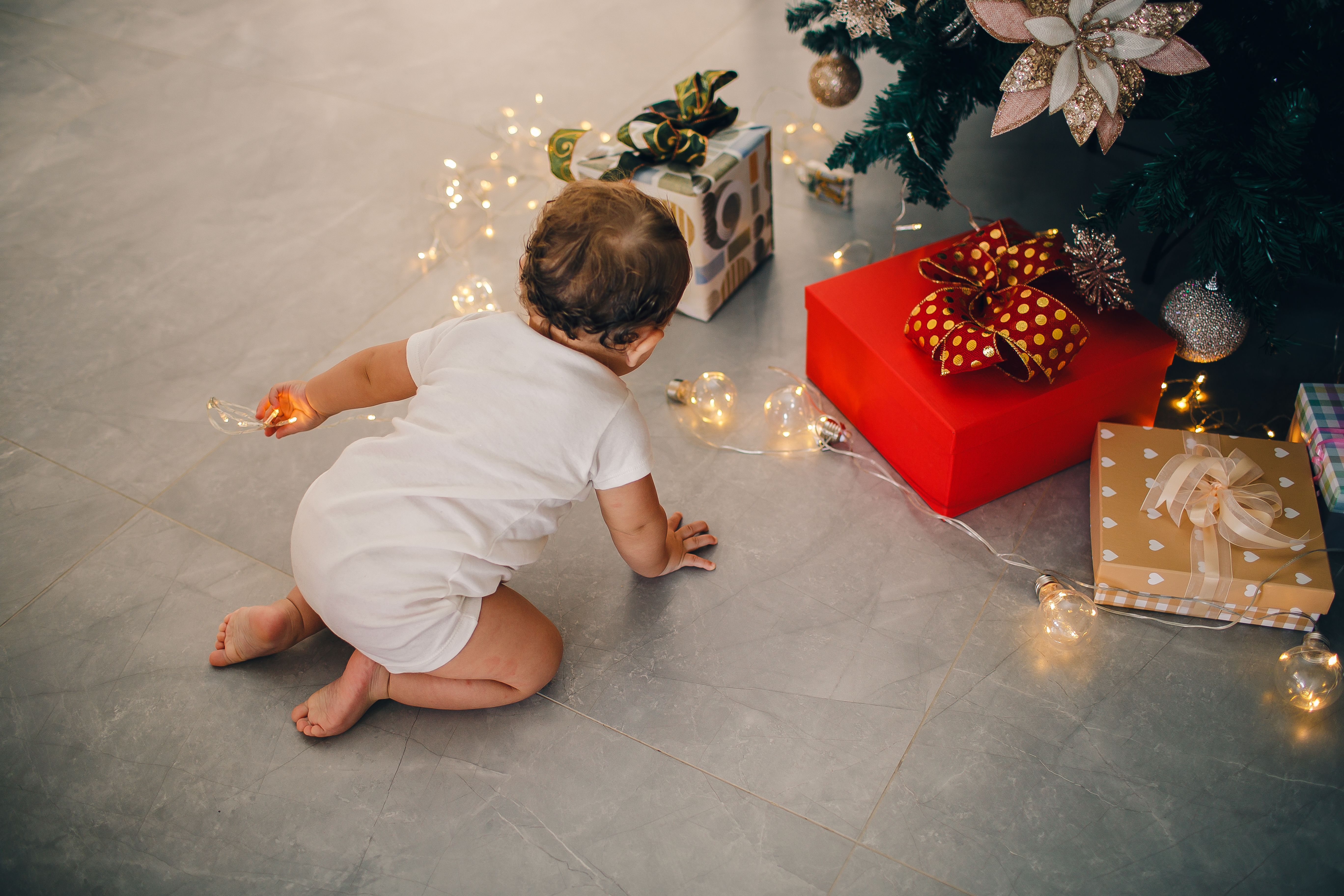 Baby Playing under Christmas Tree · Free Stock Photo