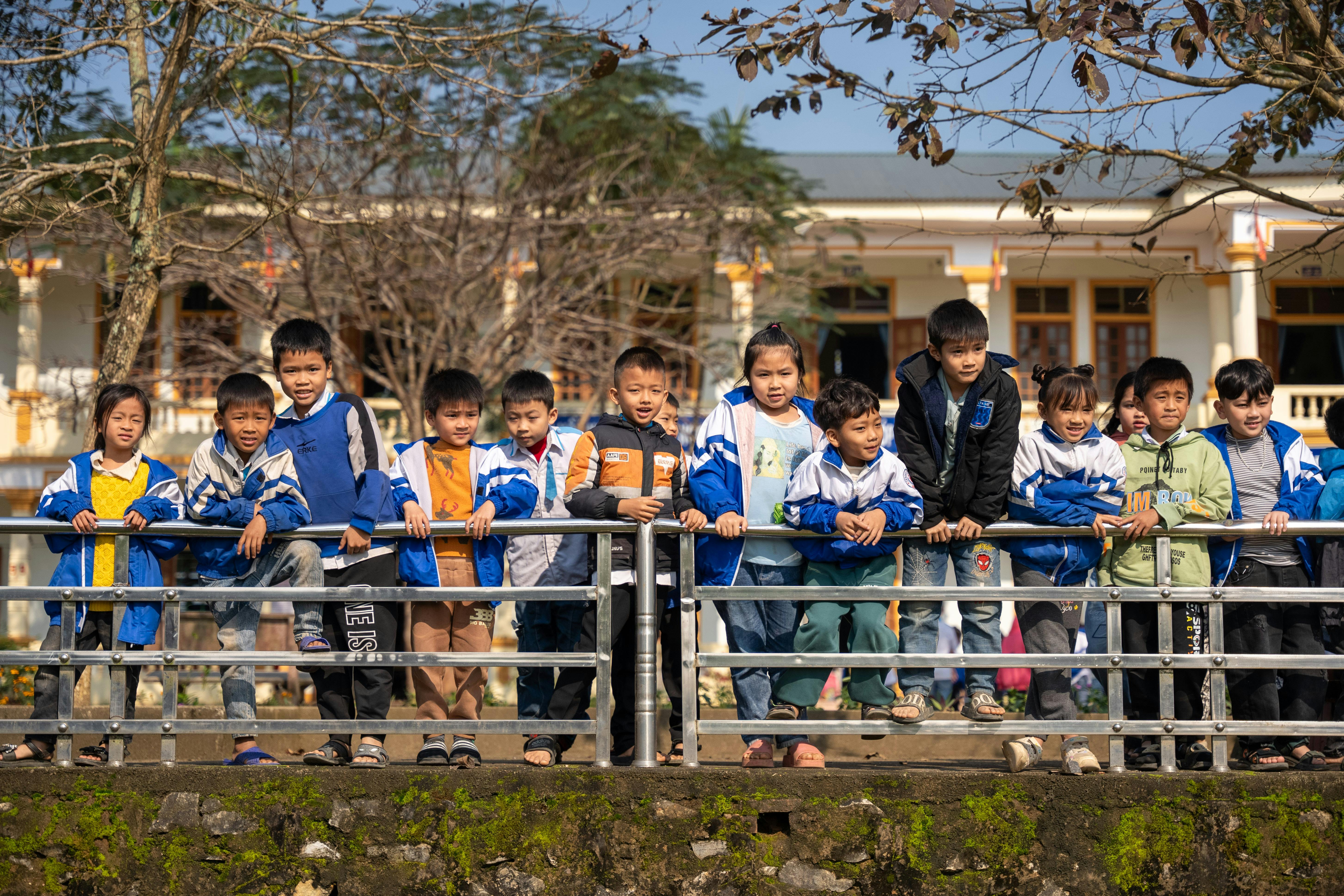 Schoolkids Standing by the Railing · Free Stock Photo