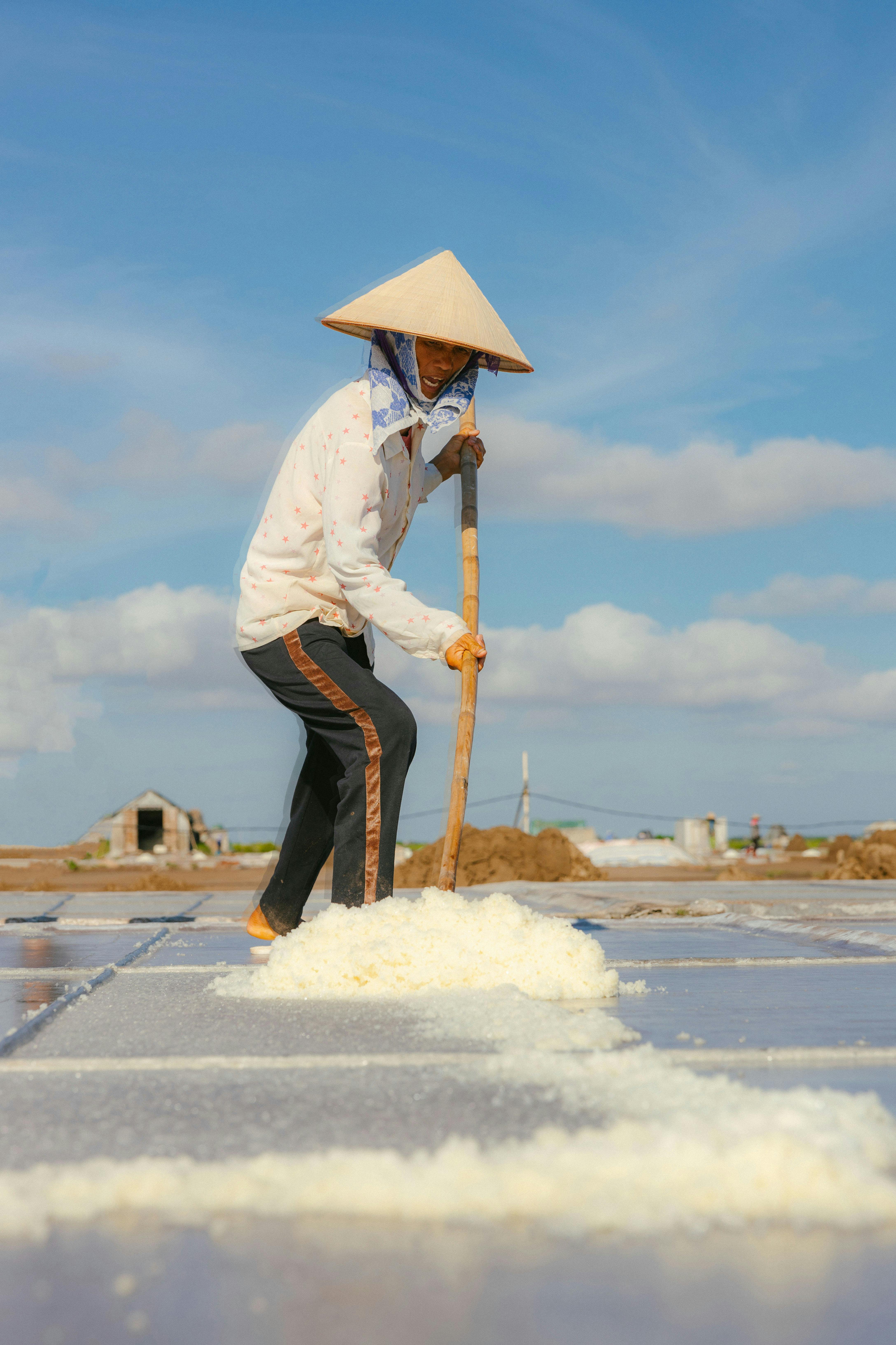 Worker Harvesting Salt Under Blue Sky · Free Stock Photo