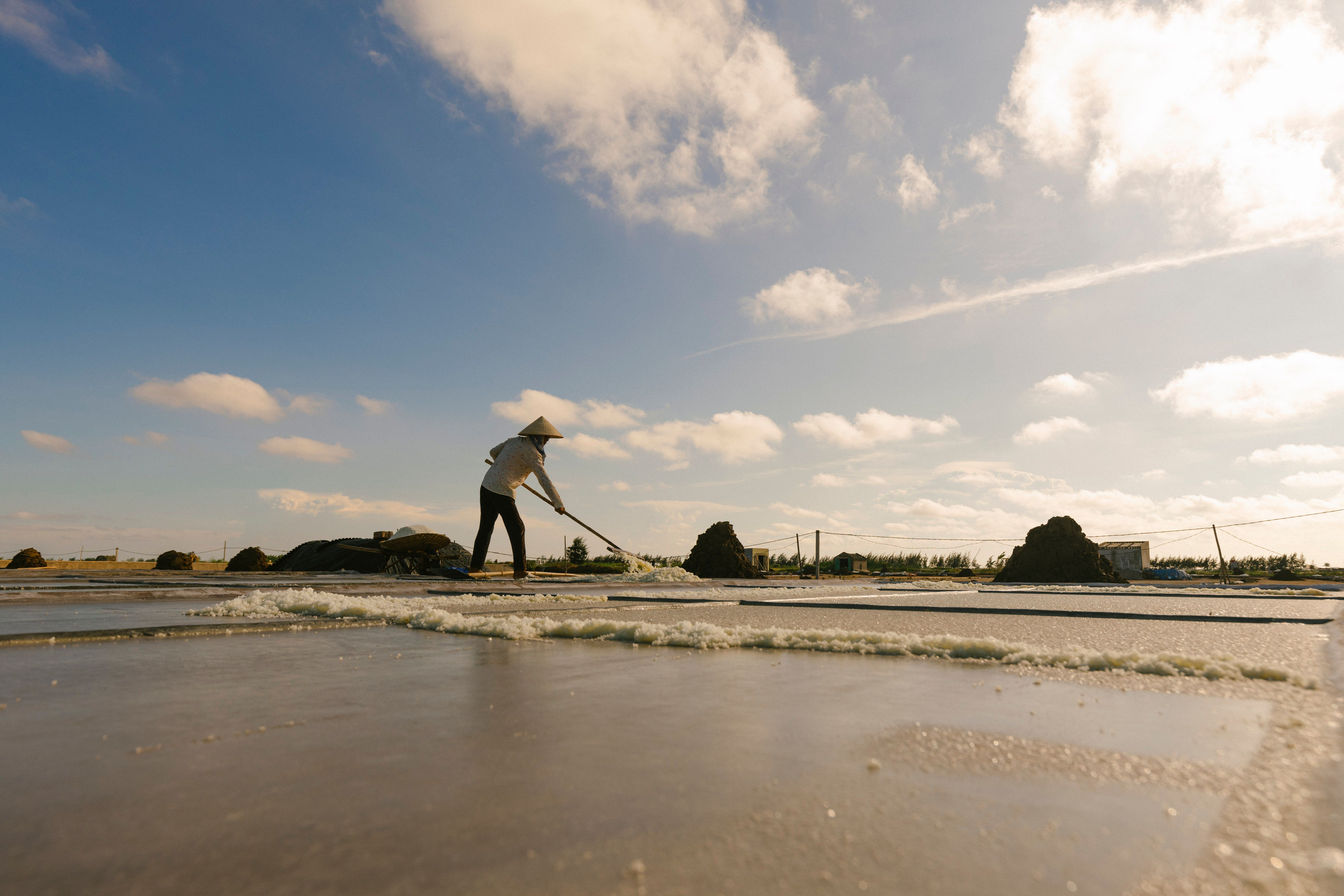 A man is standing on a concrete slab with a shovel · Free Stock Photo