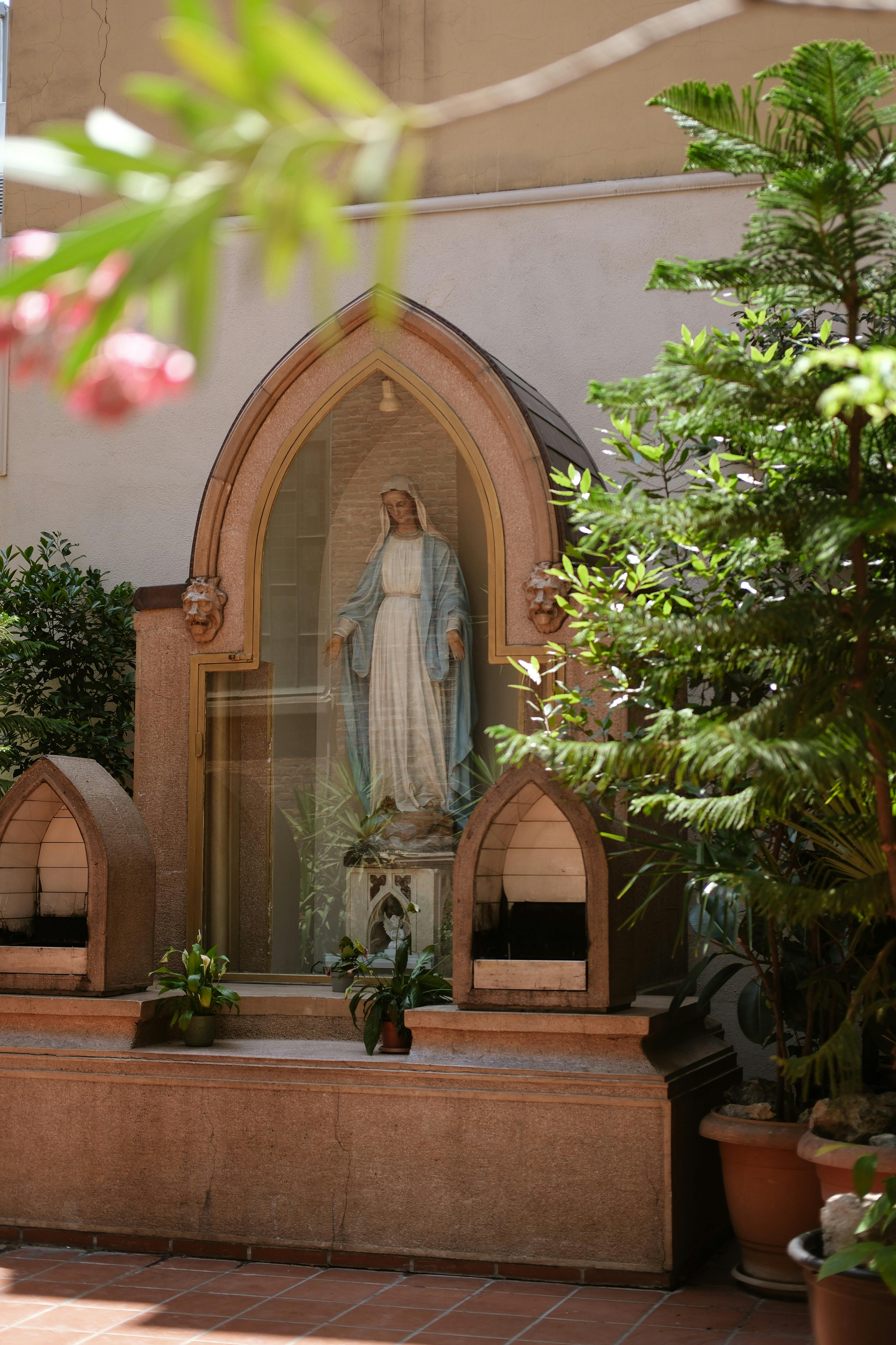 A statue of the virgin mary in a garden · Free Stock Photo