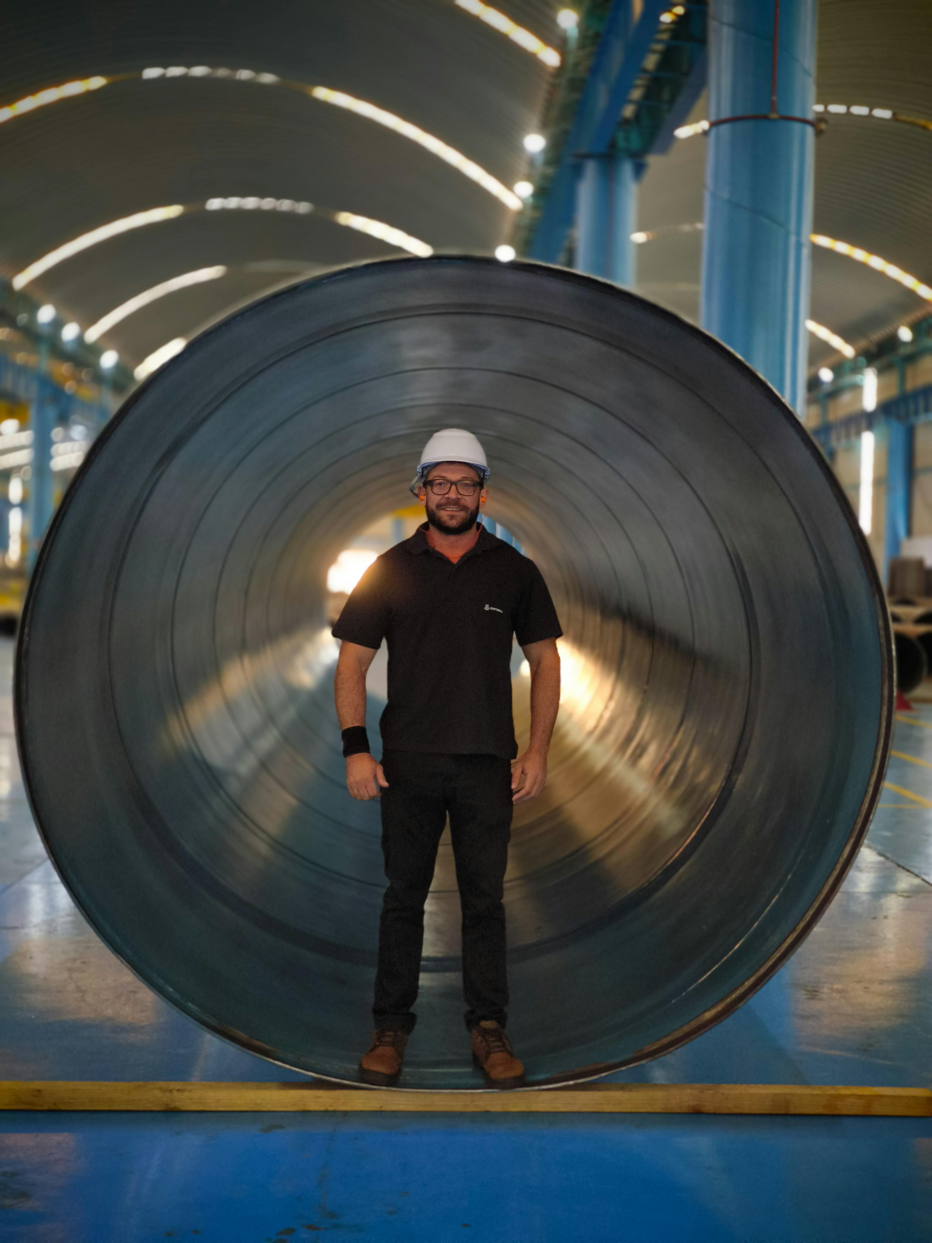 A man standing in front of a large pipe · Free Stock Photo
