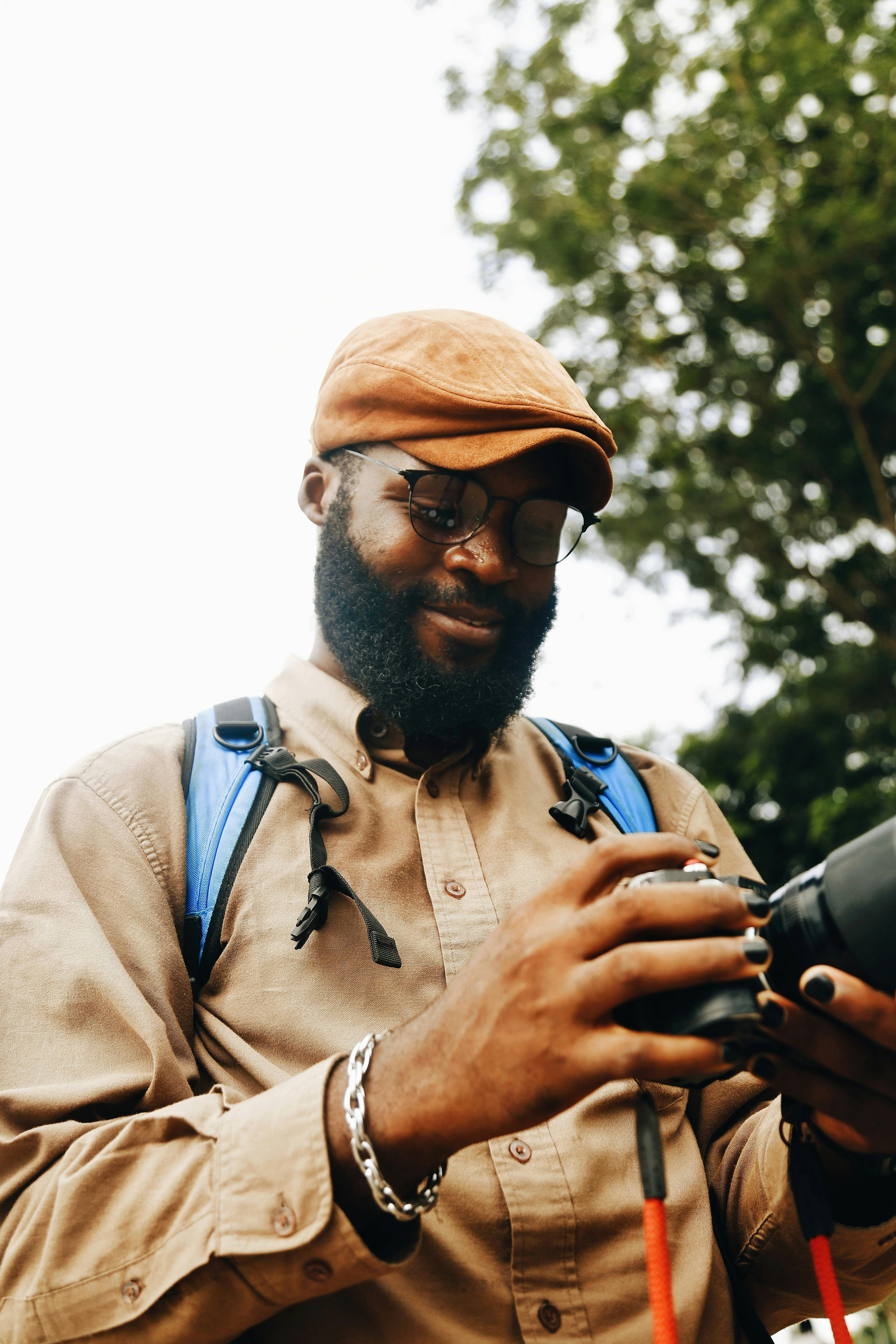 Man in Jacket Standing with Camera · Free Stock Photo