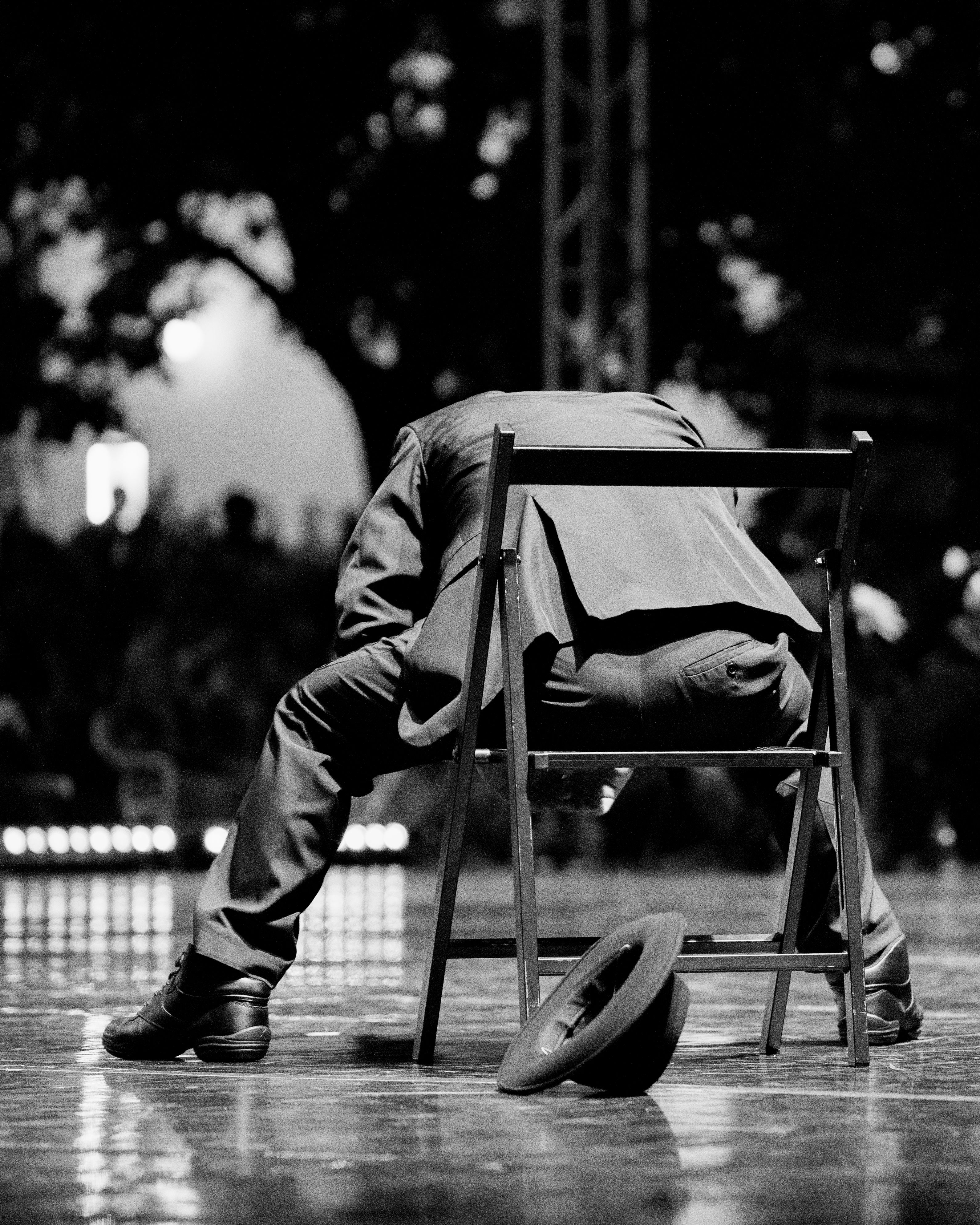 Performer in Suit Sitting on Chair on Stage · Free Stock Photo