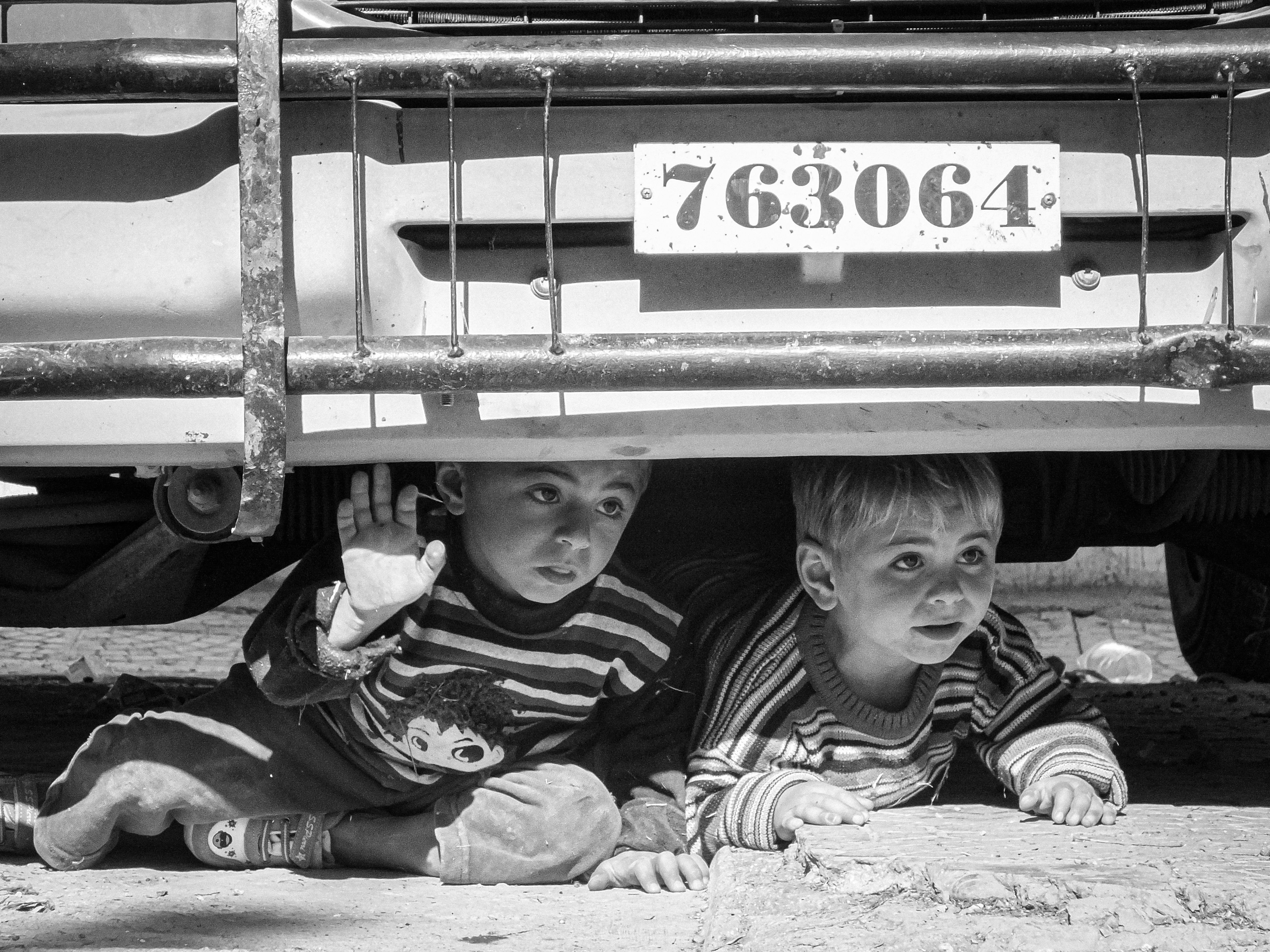 Boy Lying Down under Car · Free Stock Photo