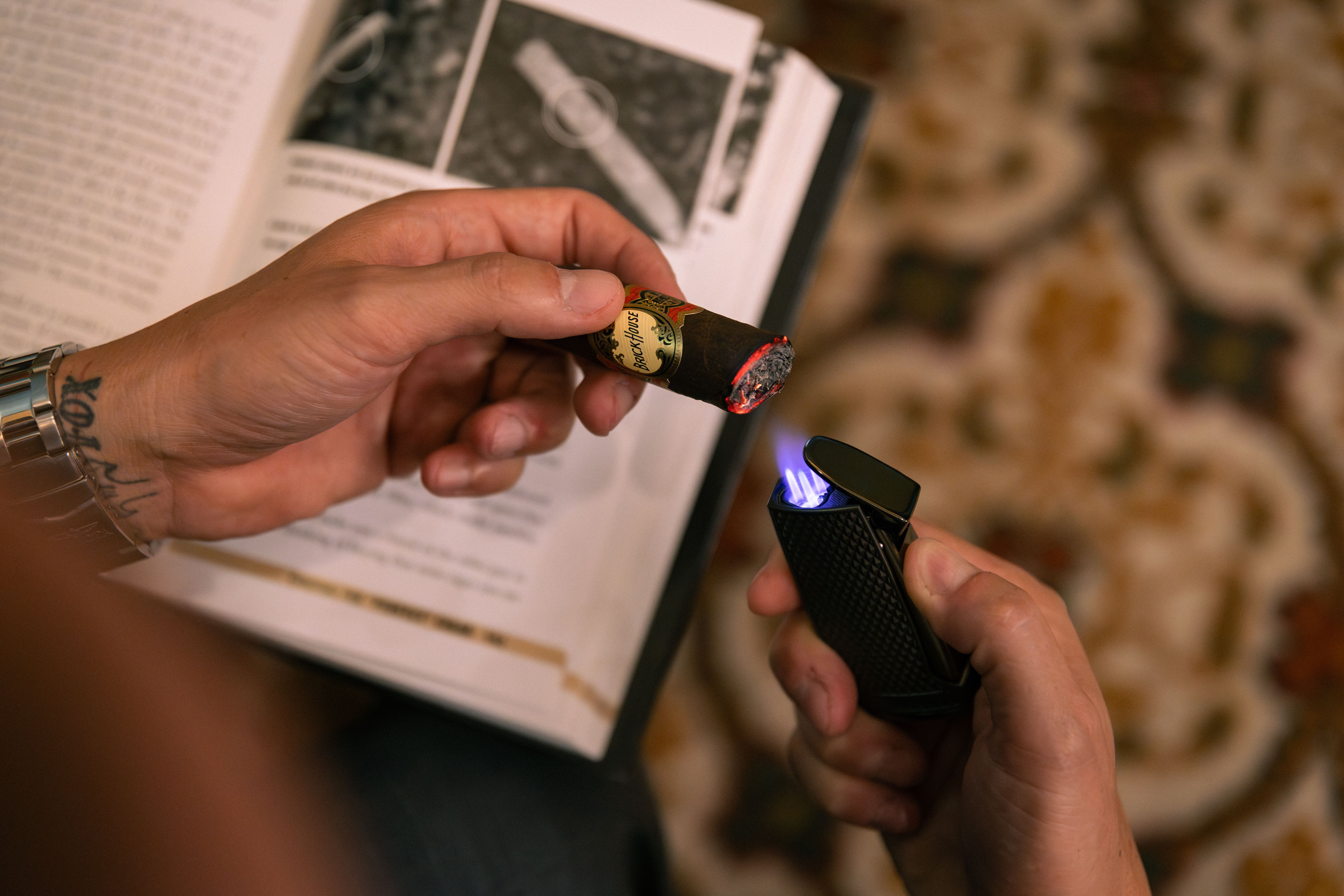 A person holding a lighter and a book · Free Stock Photo
