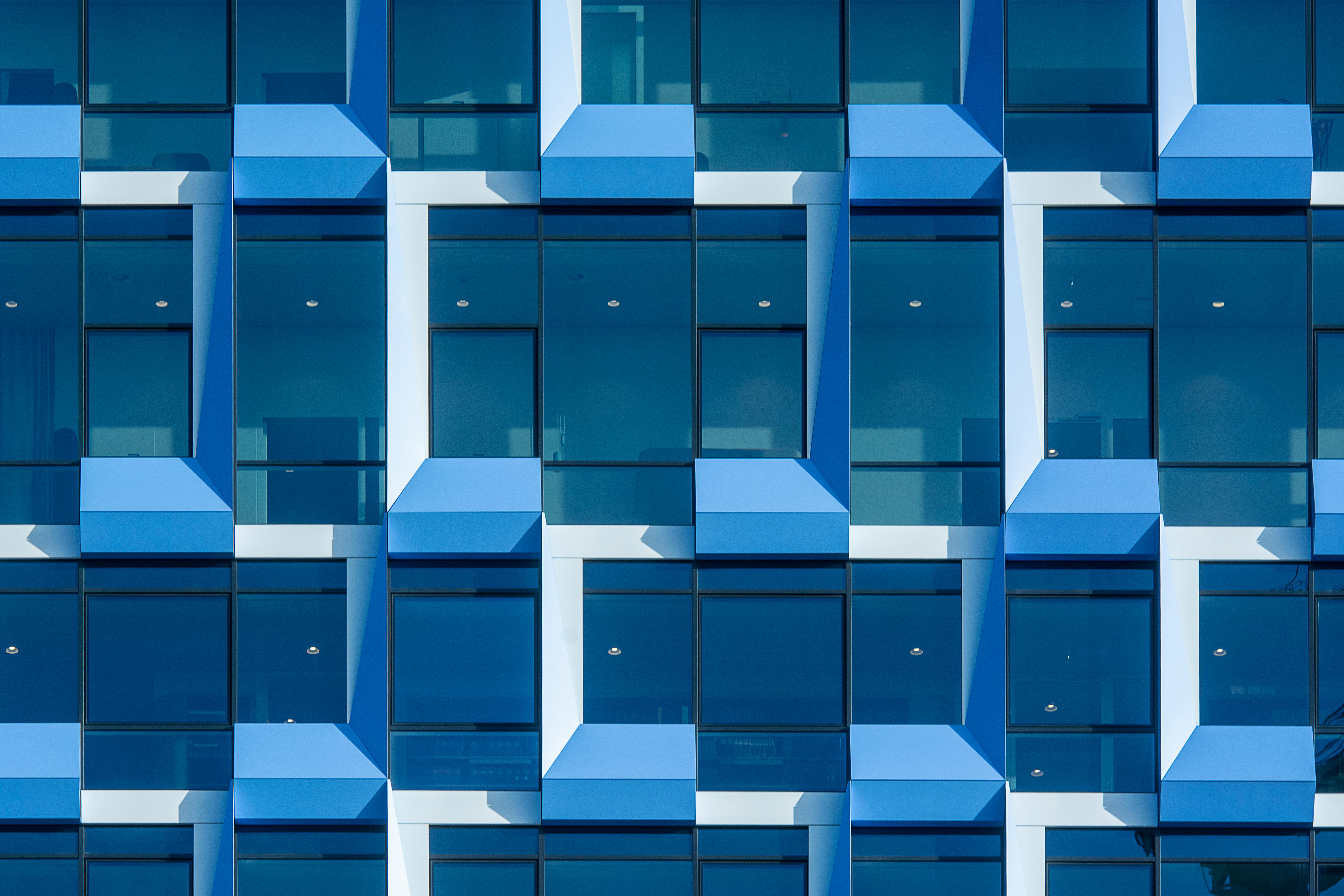 A close up of a blue building with white windows · Free Stock Photo