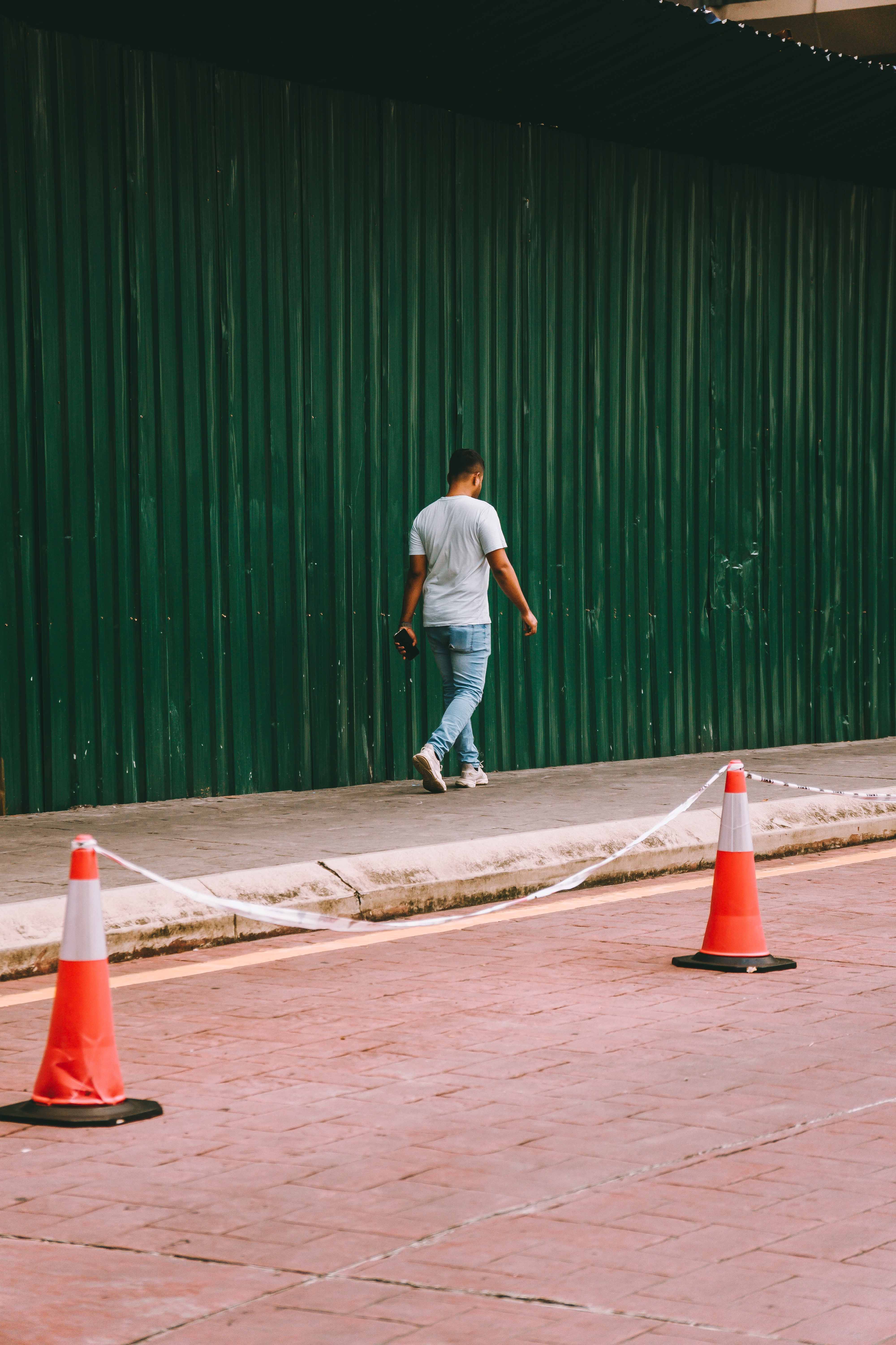 Back View of a Pedestrian Walking on the Sidewalk · Free Stock Photo