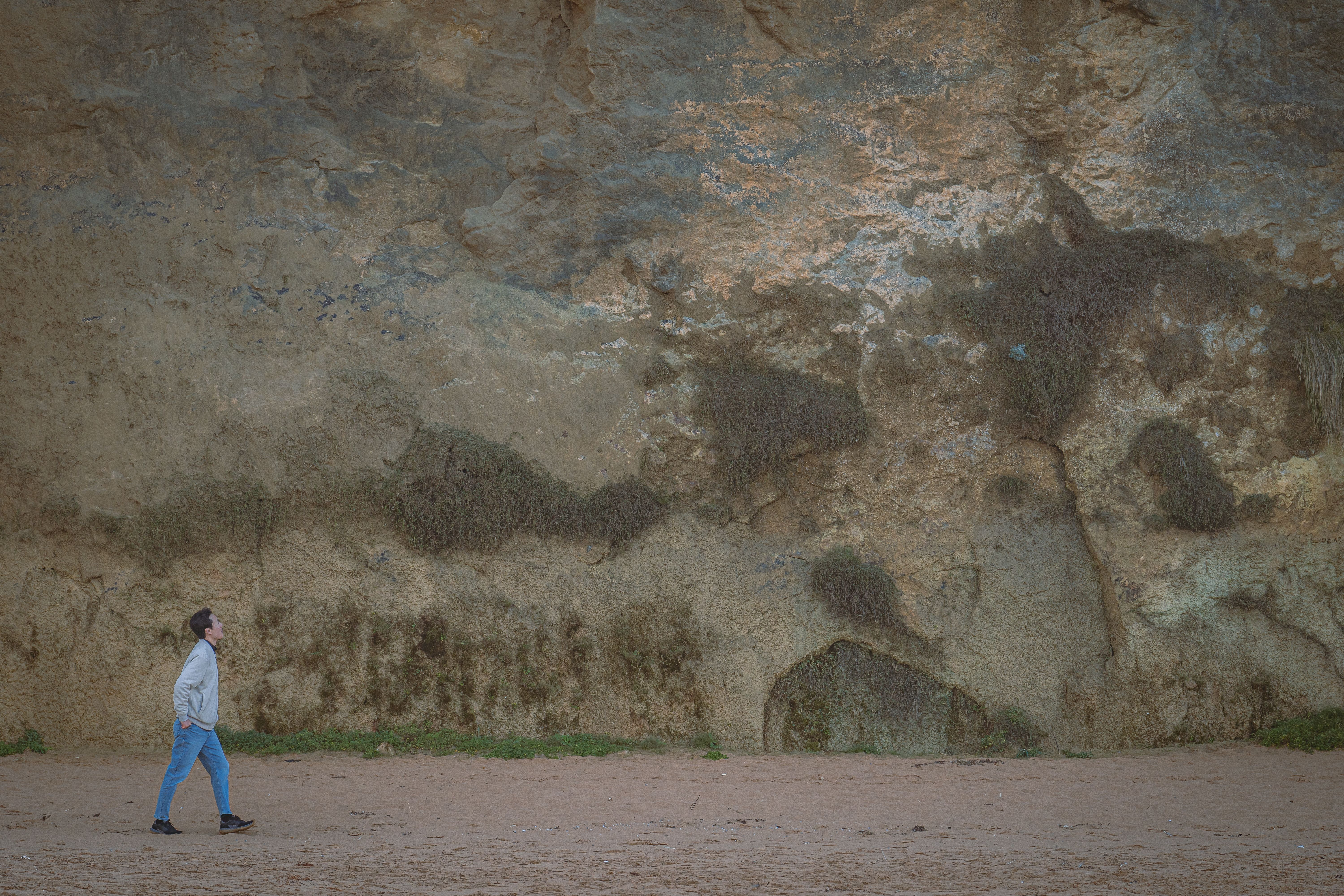 Man at the Foot of a Coastal Cliff · Free Stock Photo