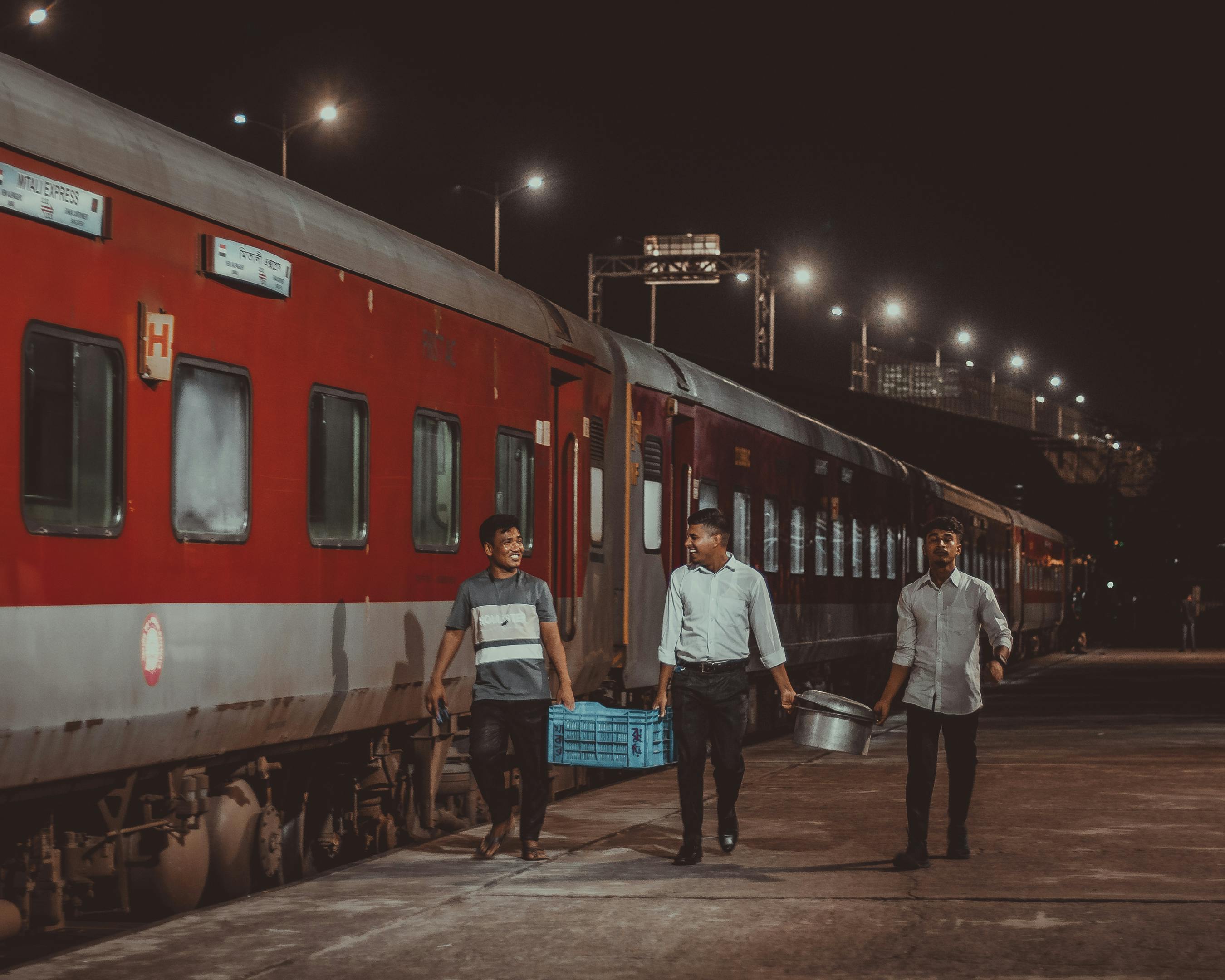 Three Men Walking on the Platform and Carrying Baskets · Free Stock Photo