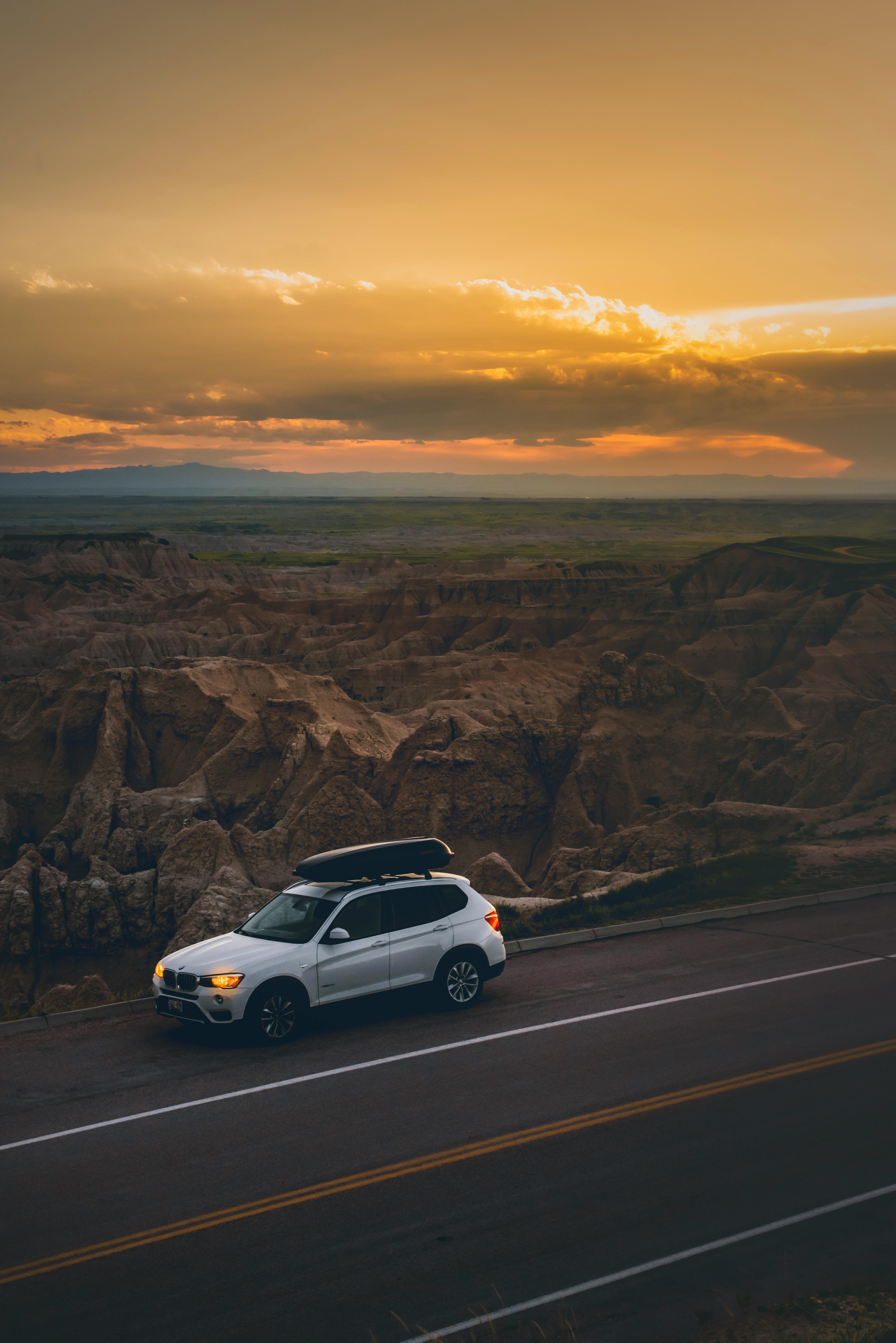Car on side of road near mountain terrain during sundown · Free Stock Photo