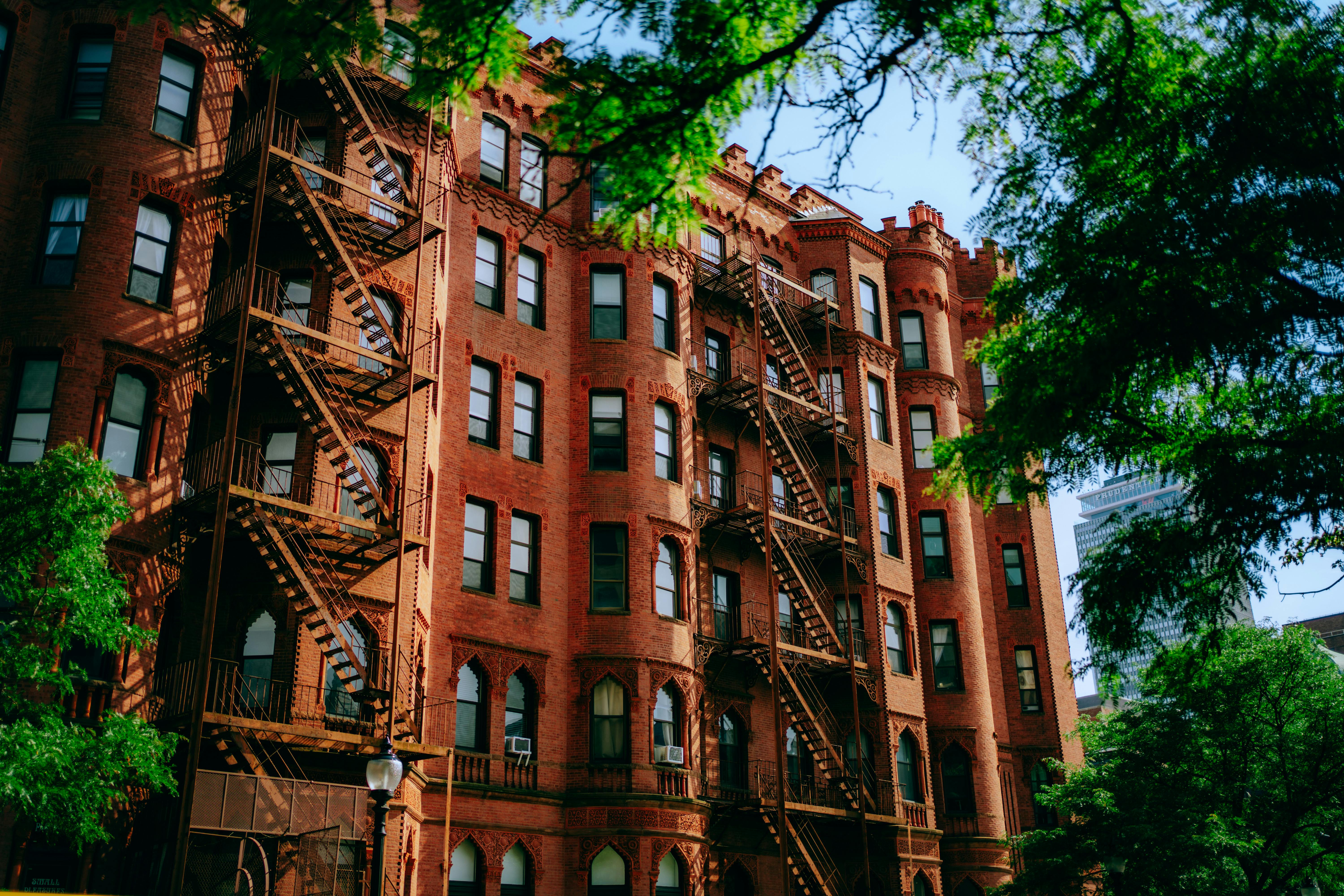 A tall red brick building with fire escapes · Free Stock Photo