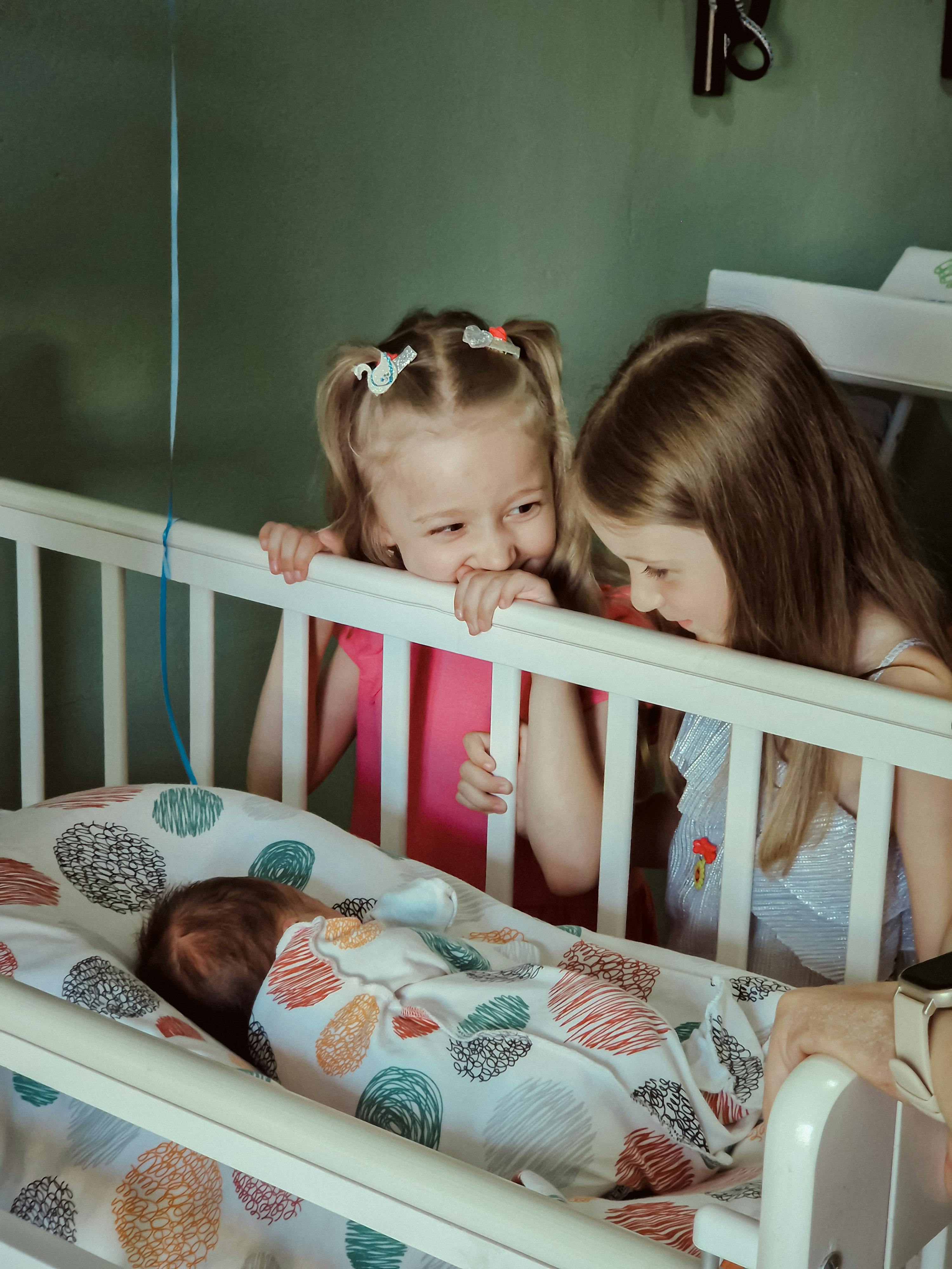 Two little girls and a baby in a crib · Free Stock Photo