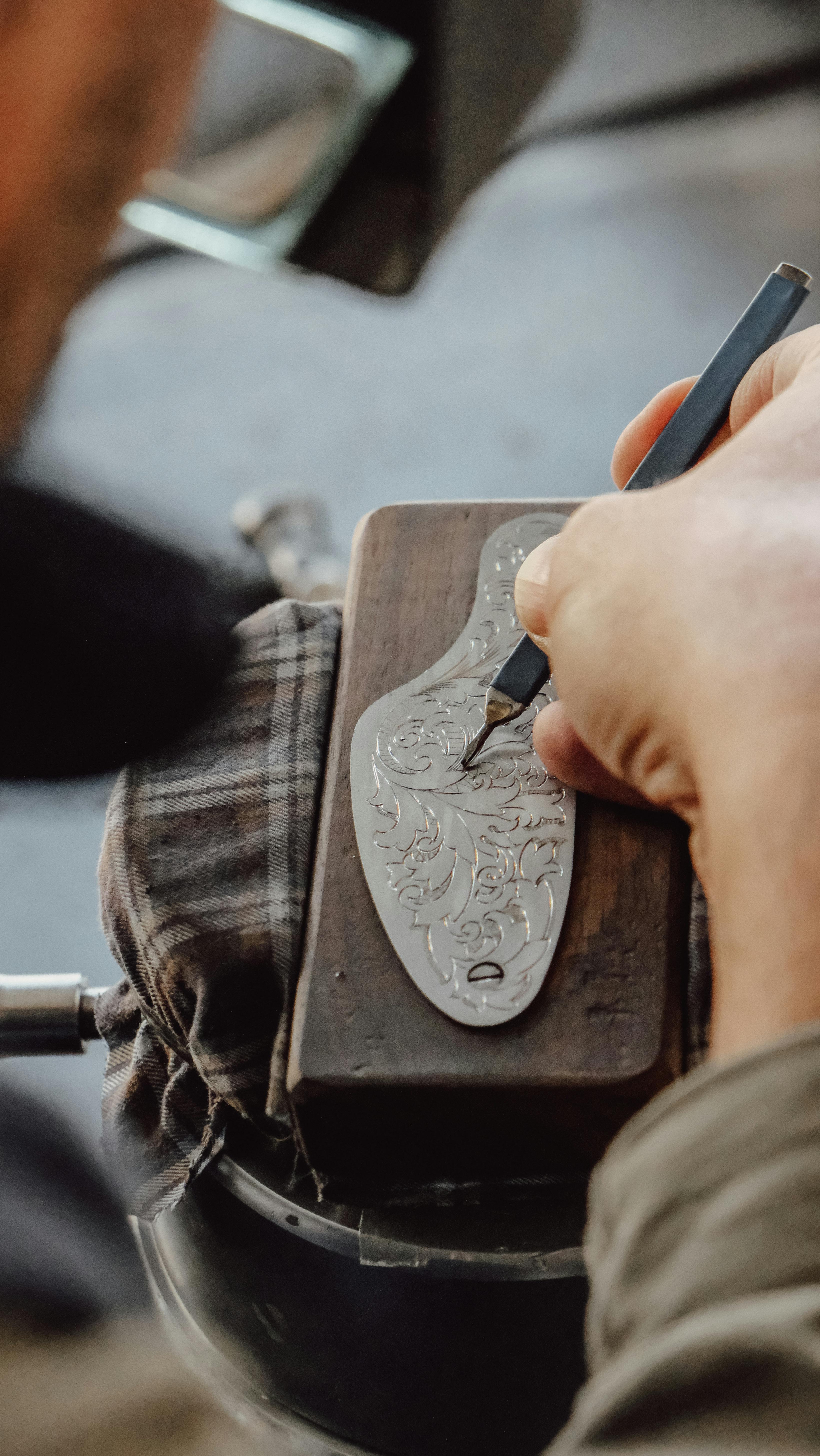 A person is using a pen to write on a piece of metal · Free Stock Photo