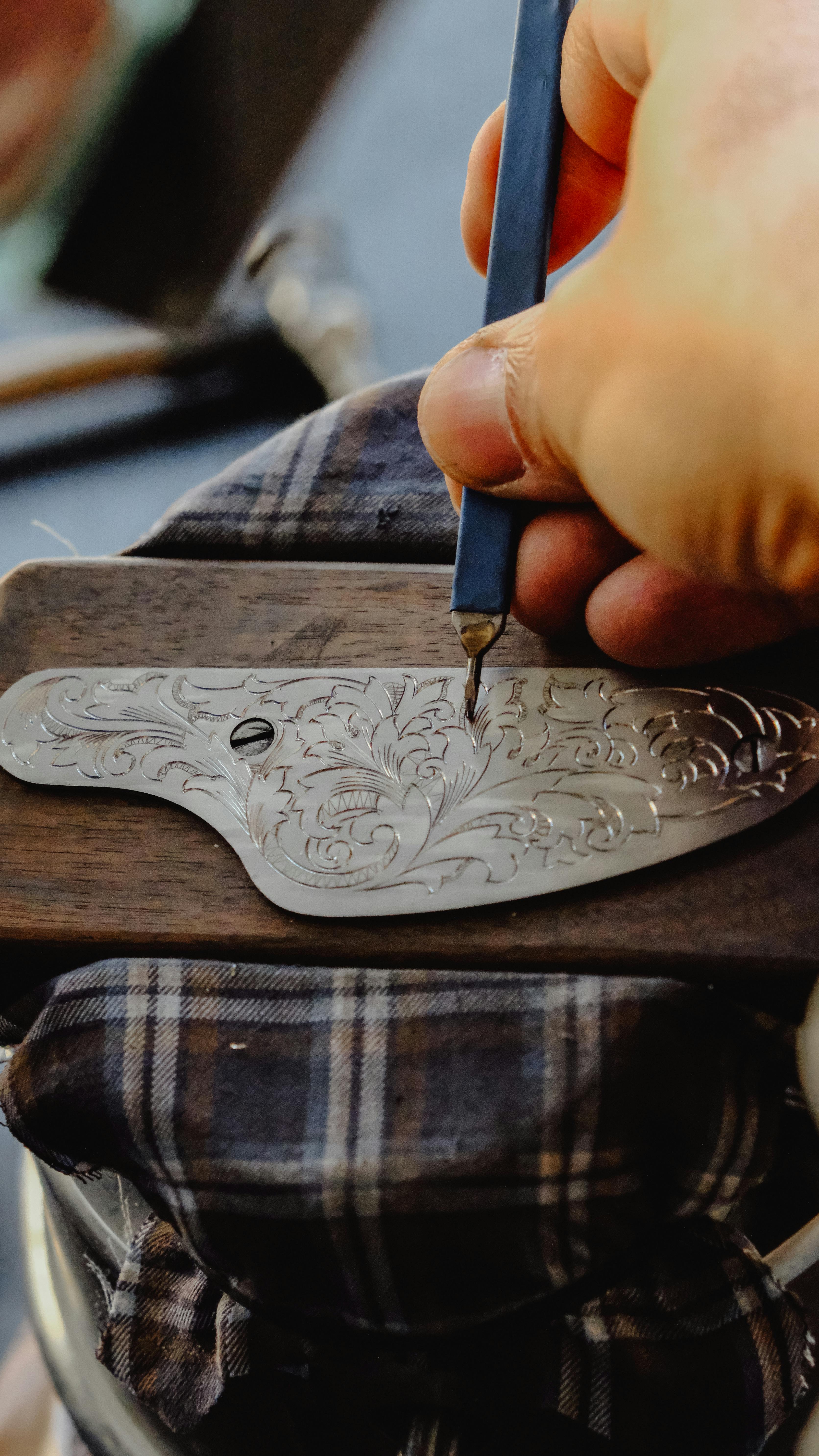 Person Inscribing Drawings Onto a Metal Belt · Free Stock Photo