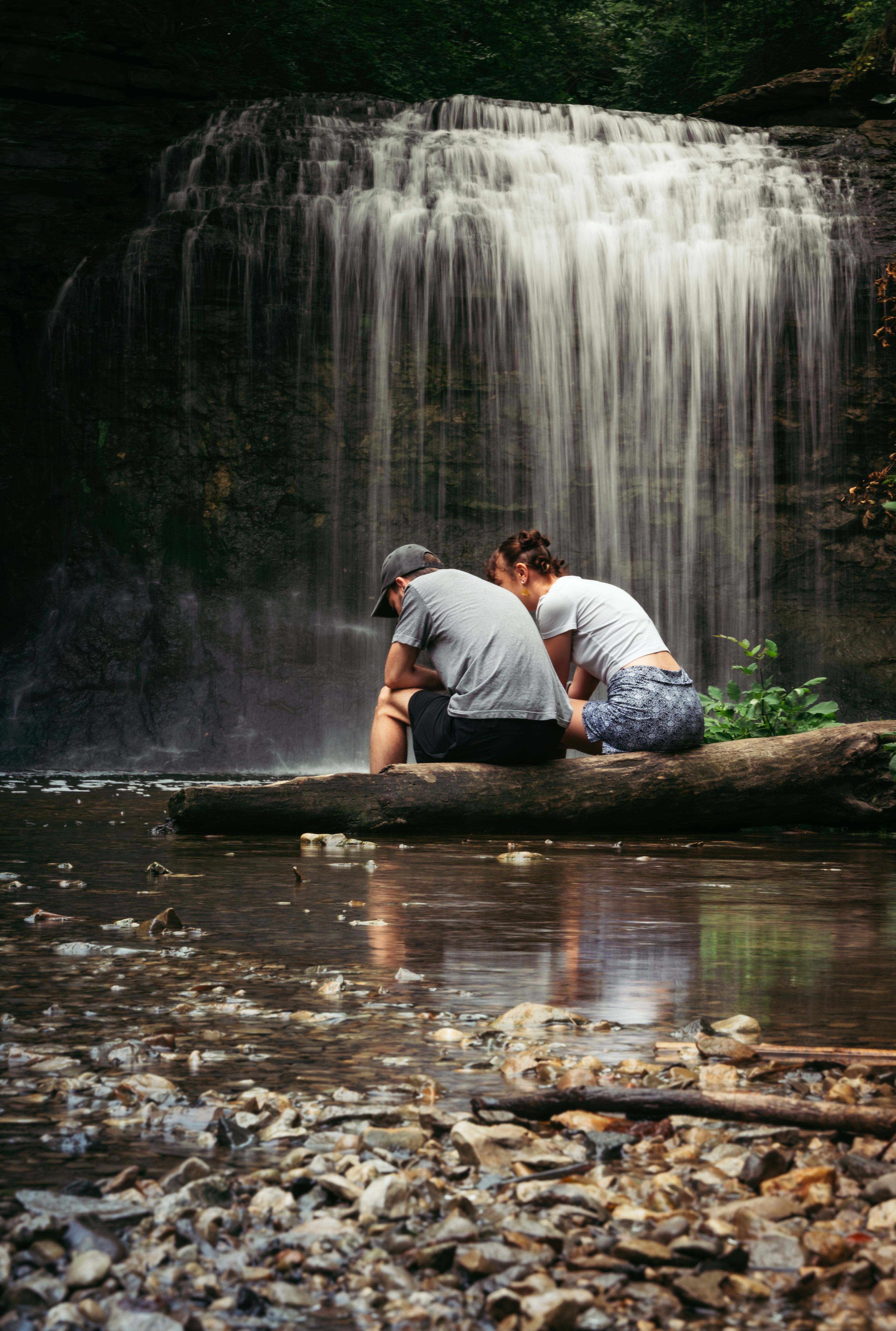 Couple Sitting near Waterfall · Free Stock Photo