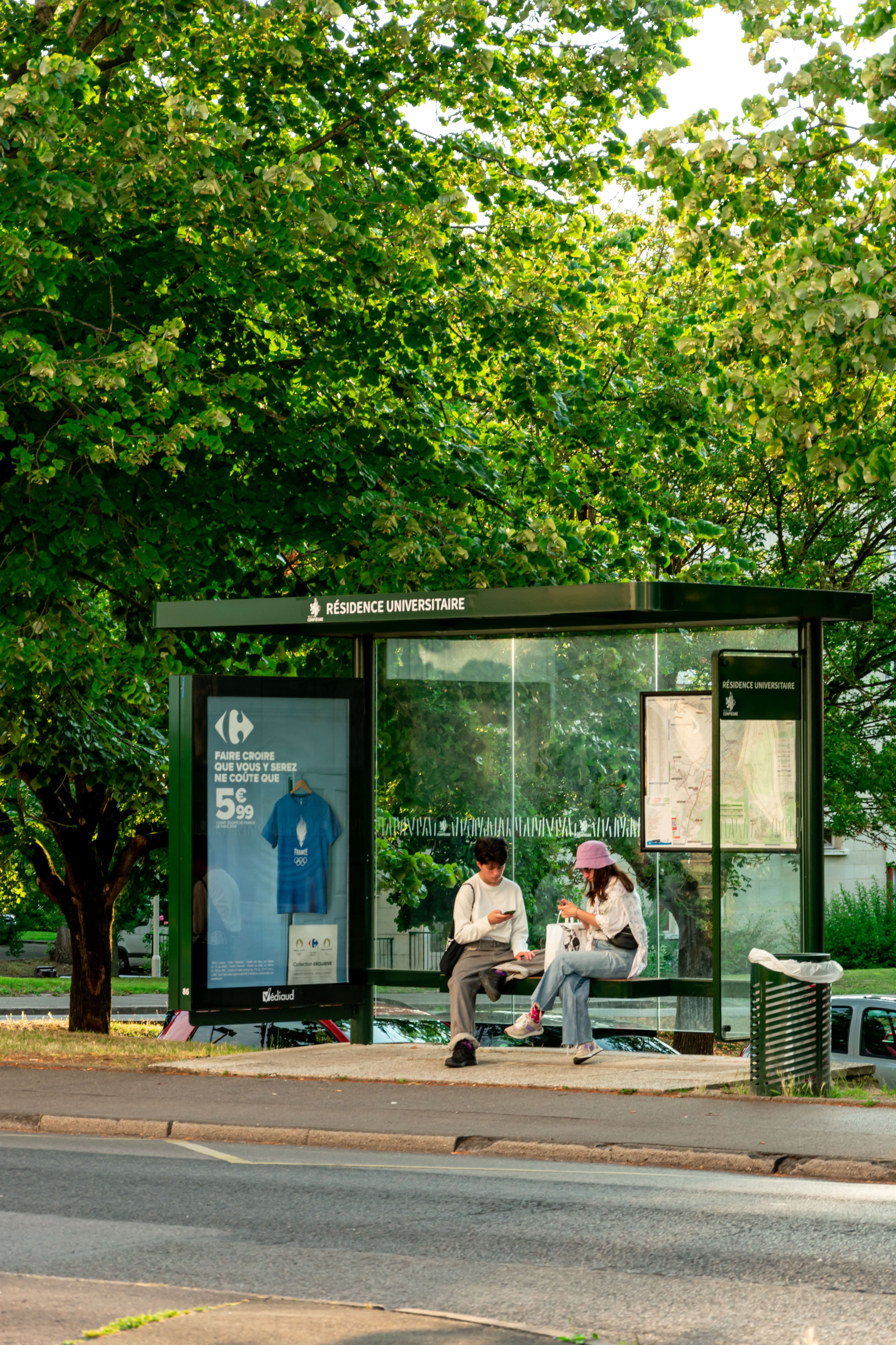 Woman and Man Sitting at Bus Stop · Free Stock Photo