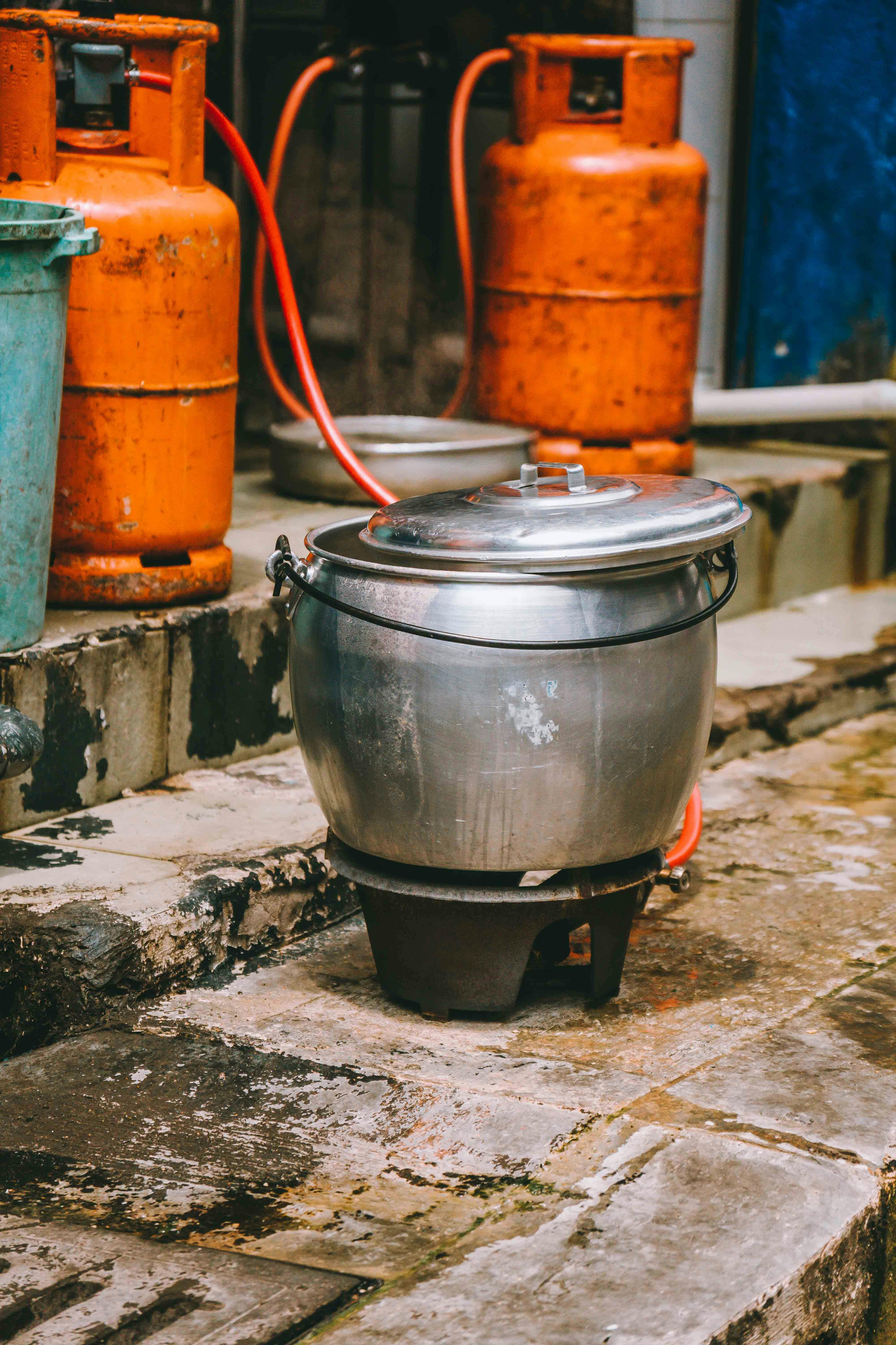 Young Boy Carrying Red Gas Cylinder Outdoors · Free Stock Photo