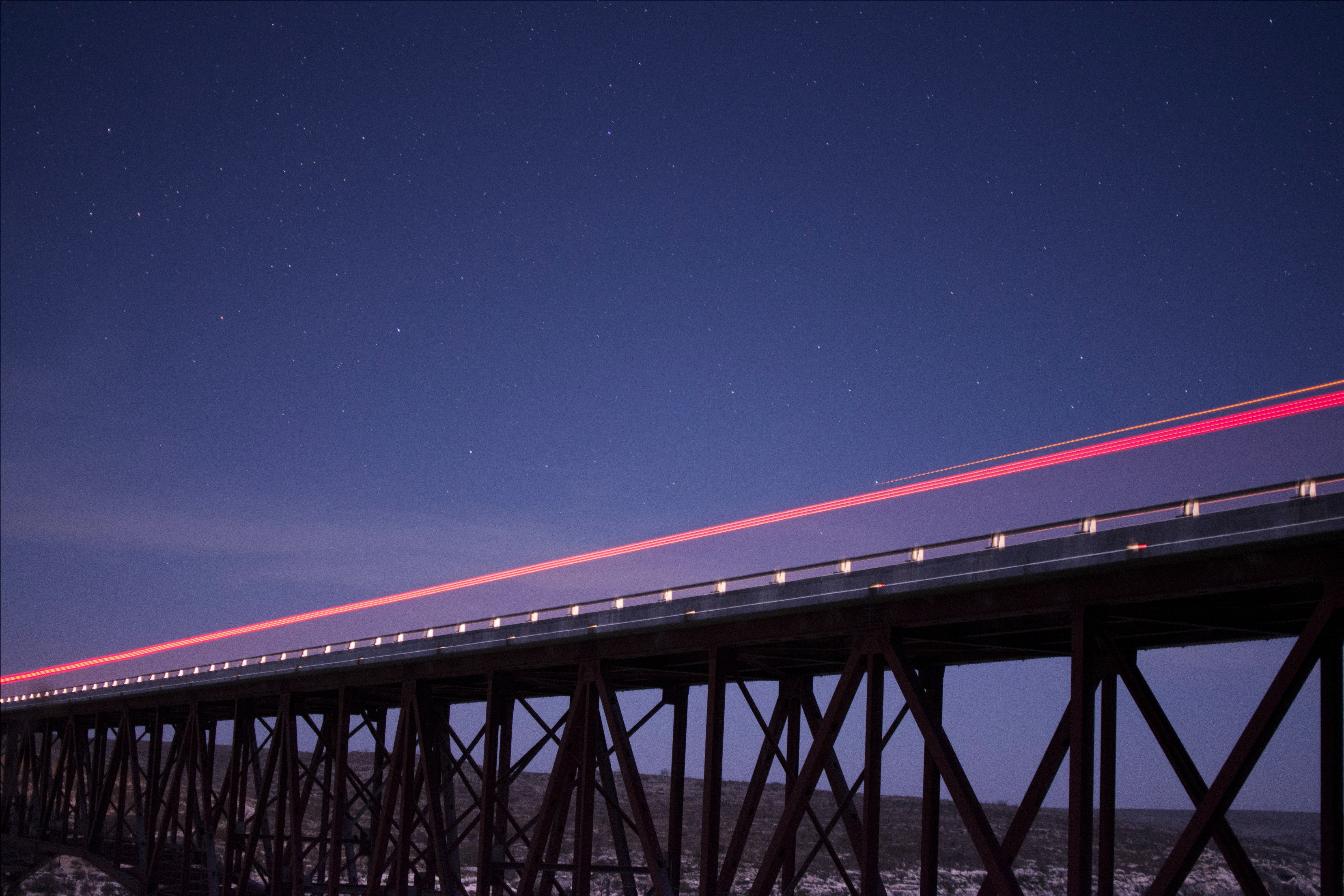A long exposure of a train crossing a bridge at night · Free Stock Photo