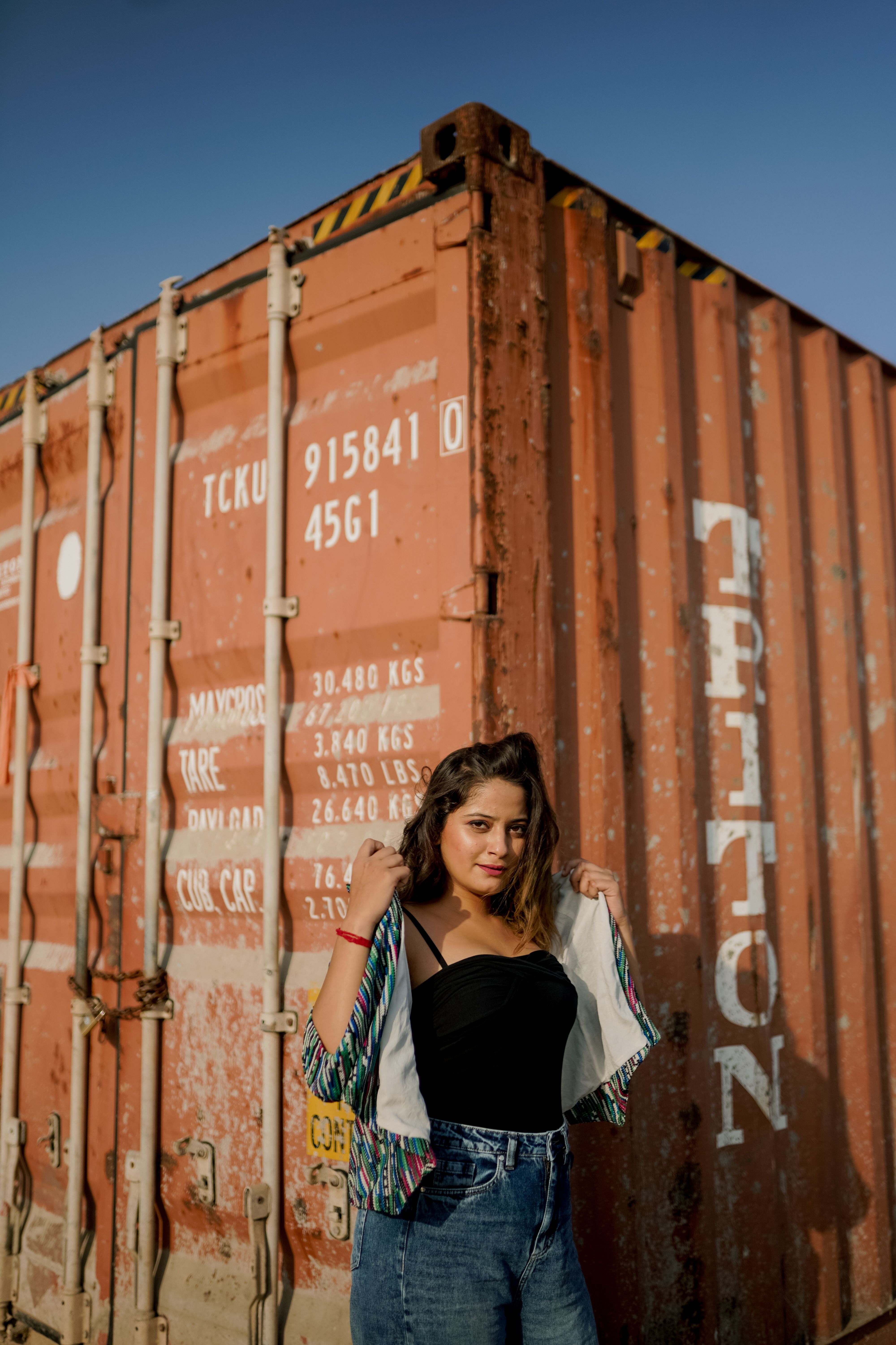 A Woman Posing by a Shipping Container · Free Stock Photo
