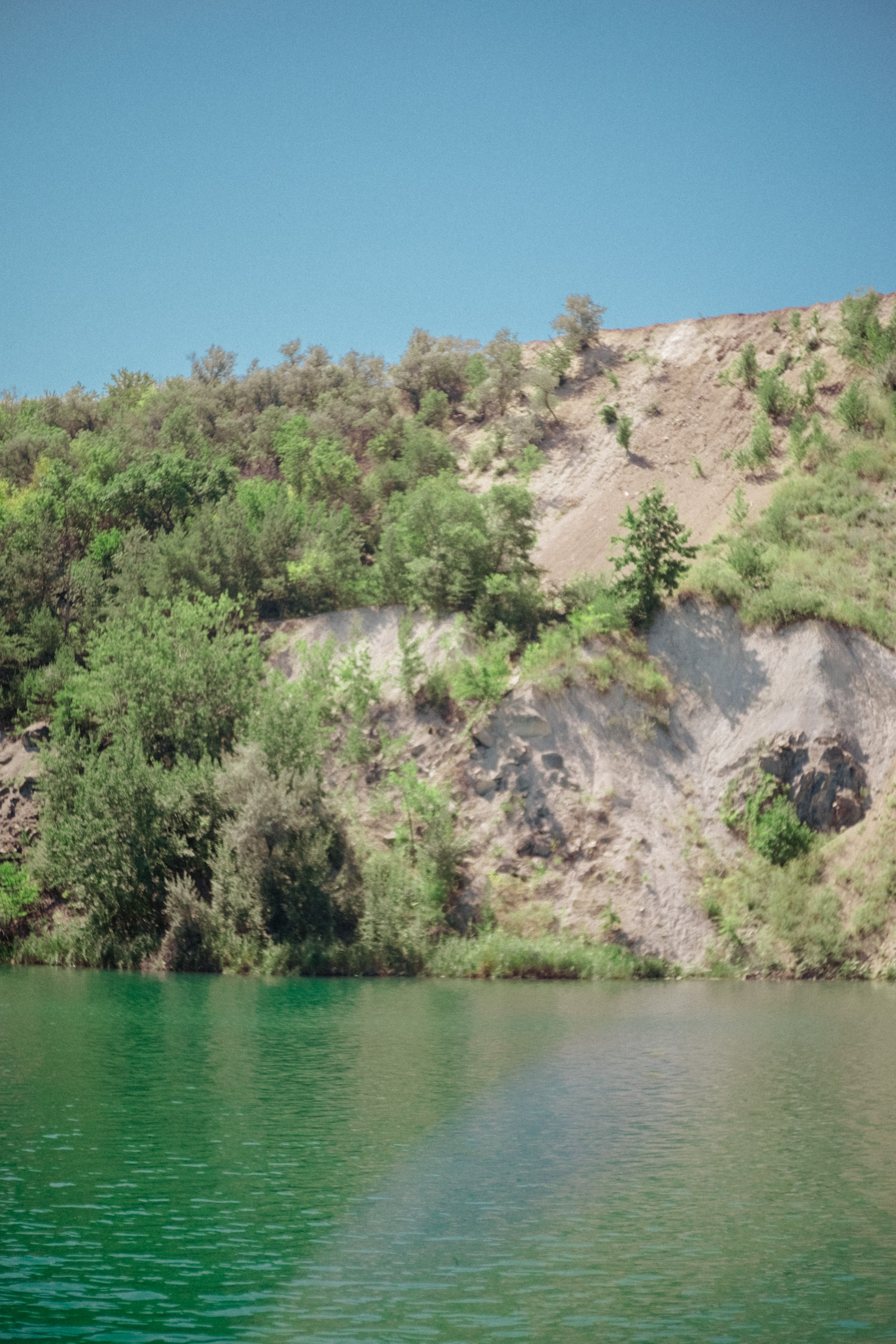 A lake with a green water and a cliff · Free Stock Photo