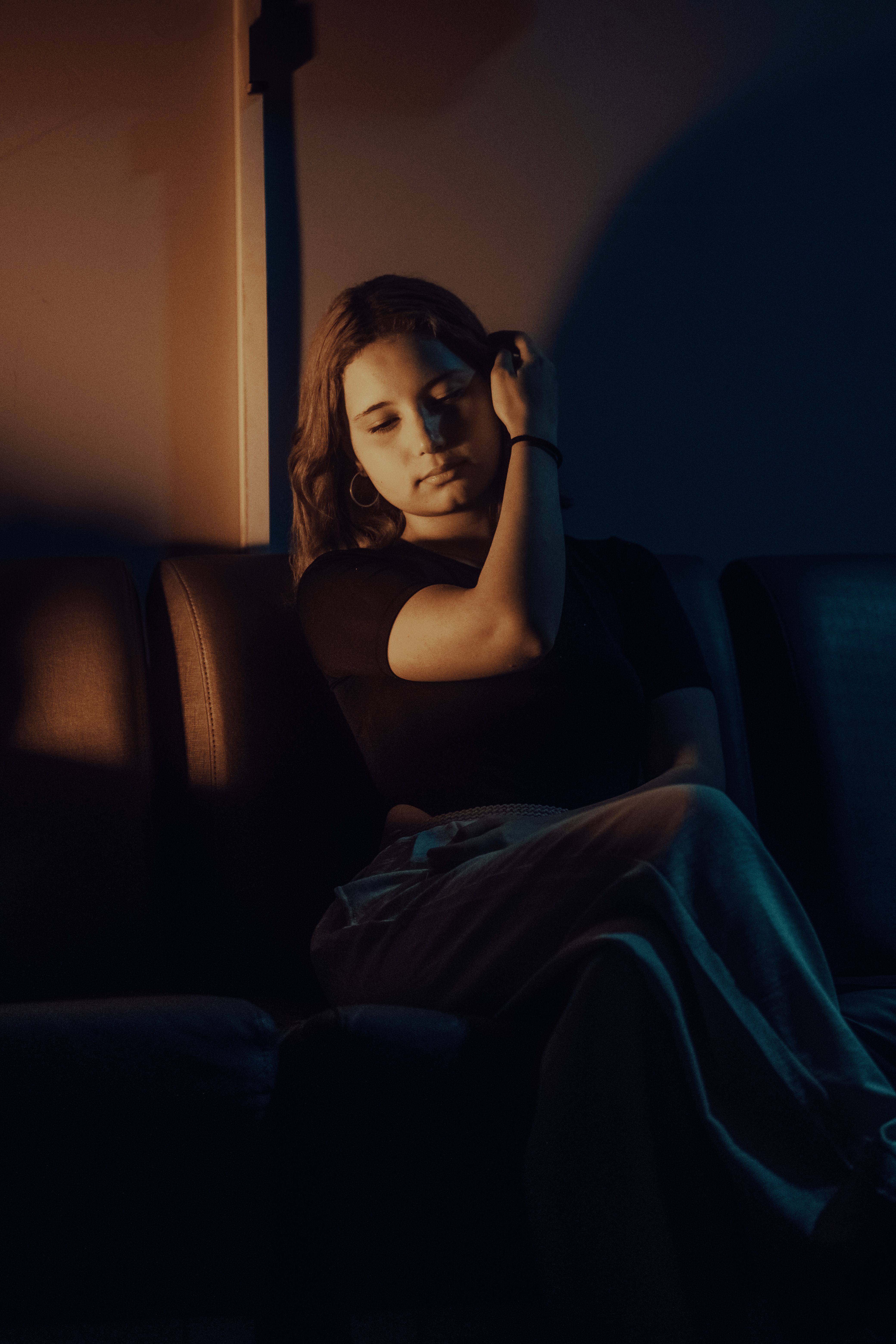 Young Woman Sitting in a Dark Room · Free Stock Photo