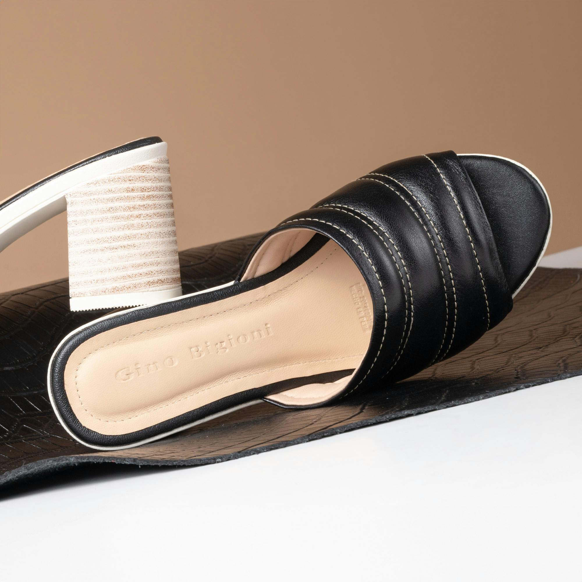 A pair of black and white sandals on a black and white table · Free ...