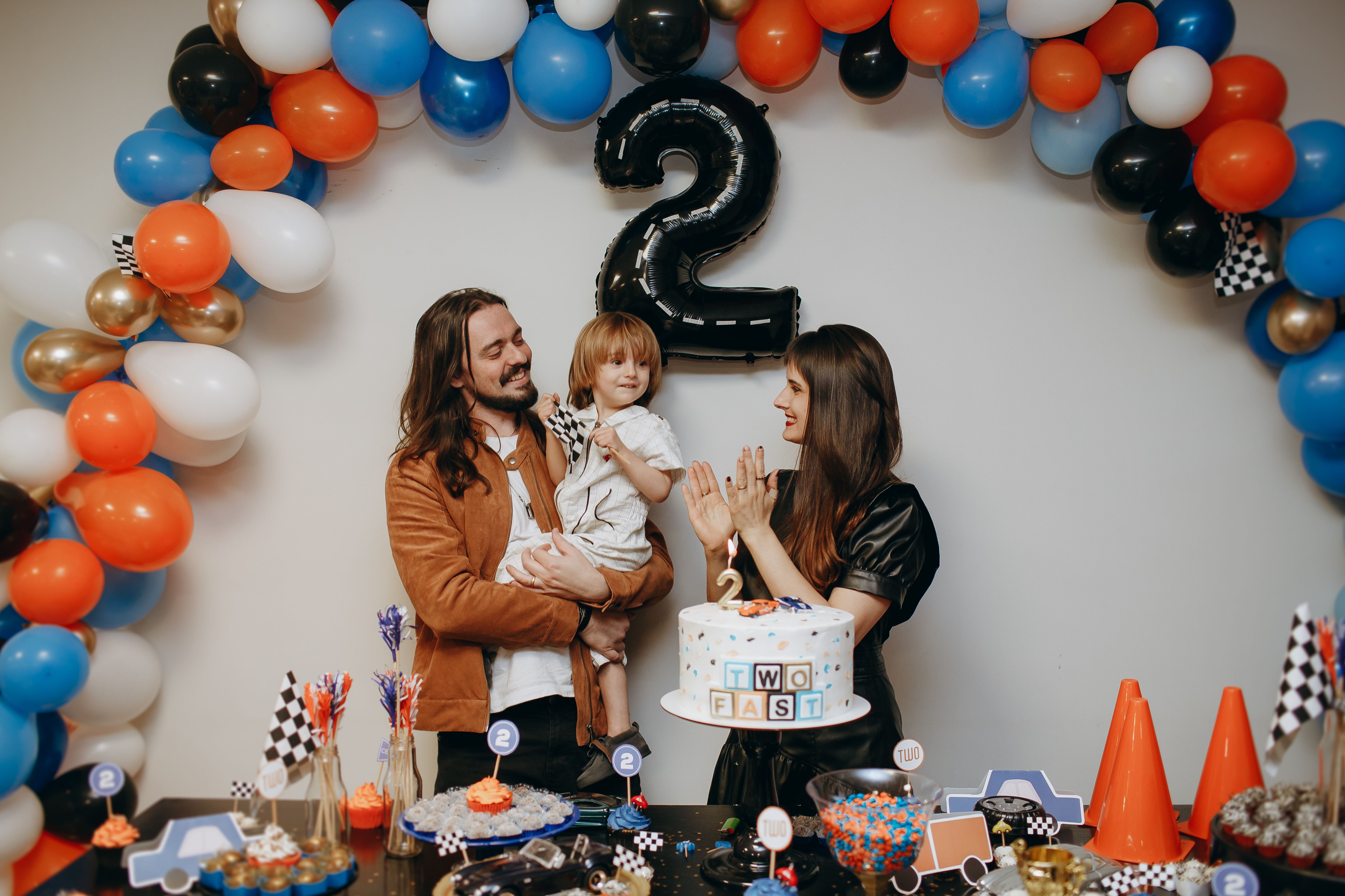 Parents Holding Their Child Posing on His Birthday Party · Free Stock Photo