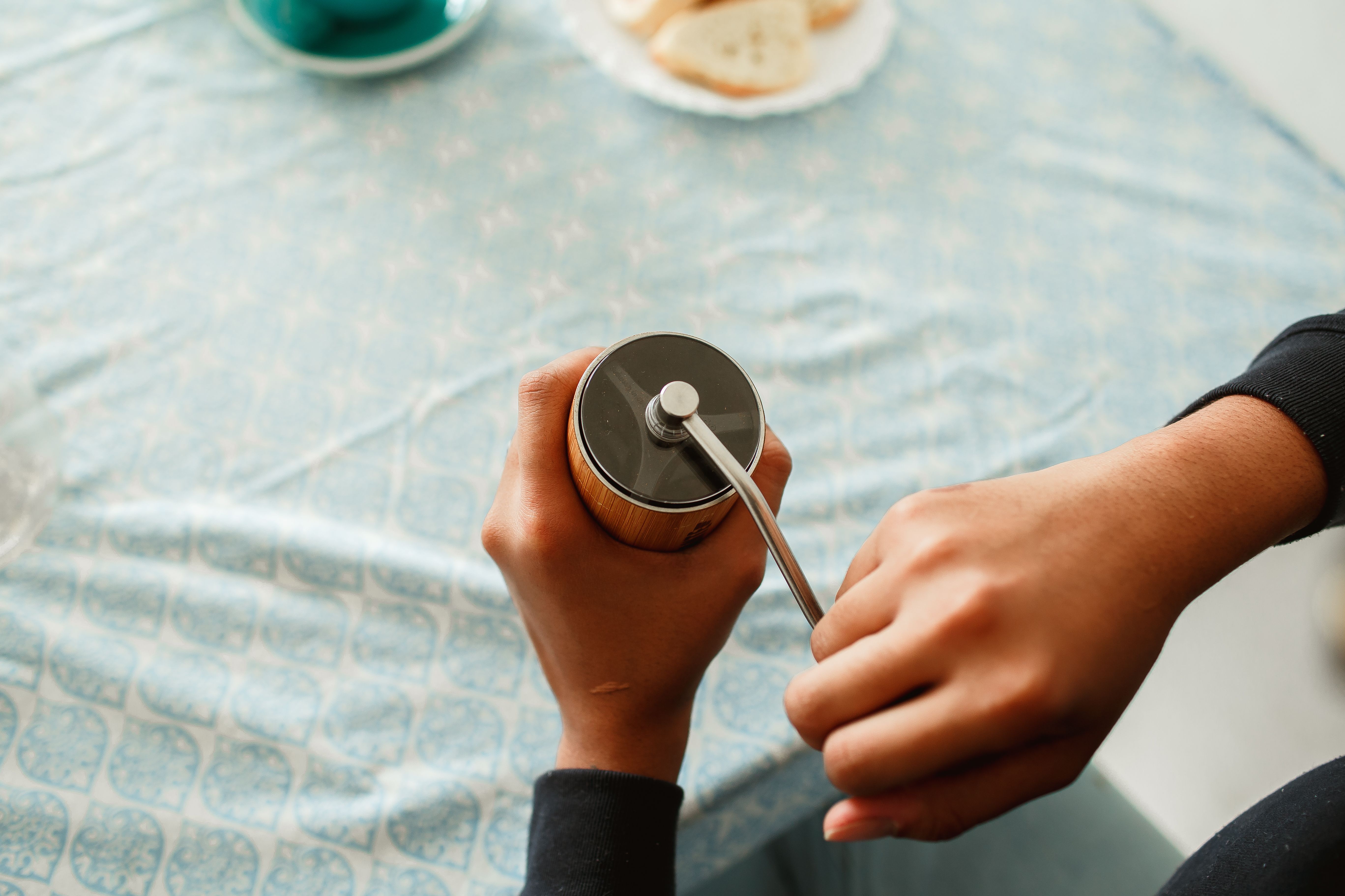 Person Grinding Coffee Beans with Manual Hand Grinder · Free Stock Photo