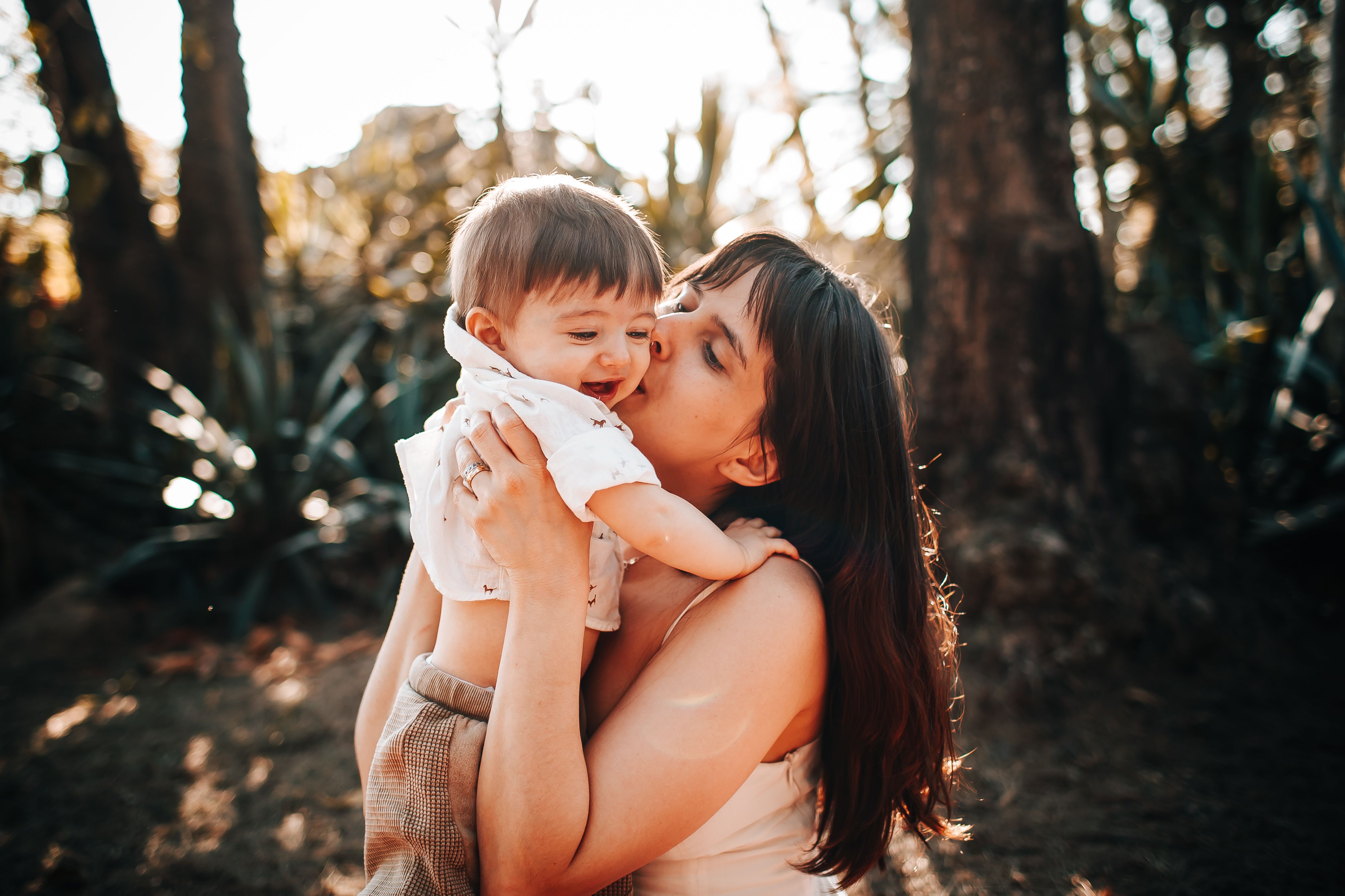 Brunette Mother Embracing Child in Park · Free Stock Photo