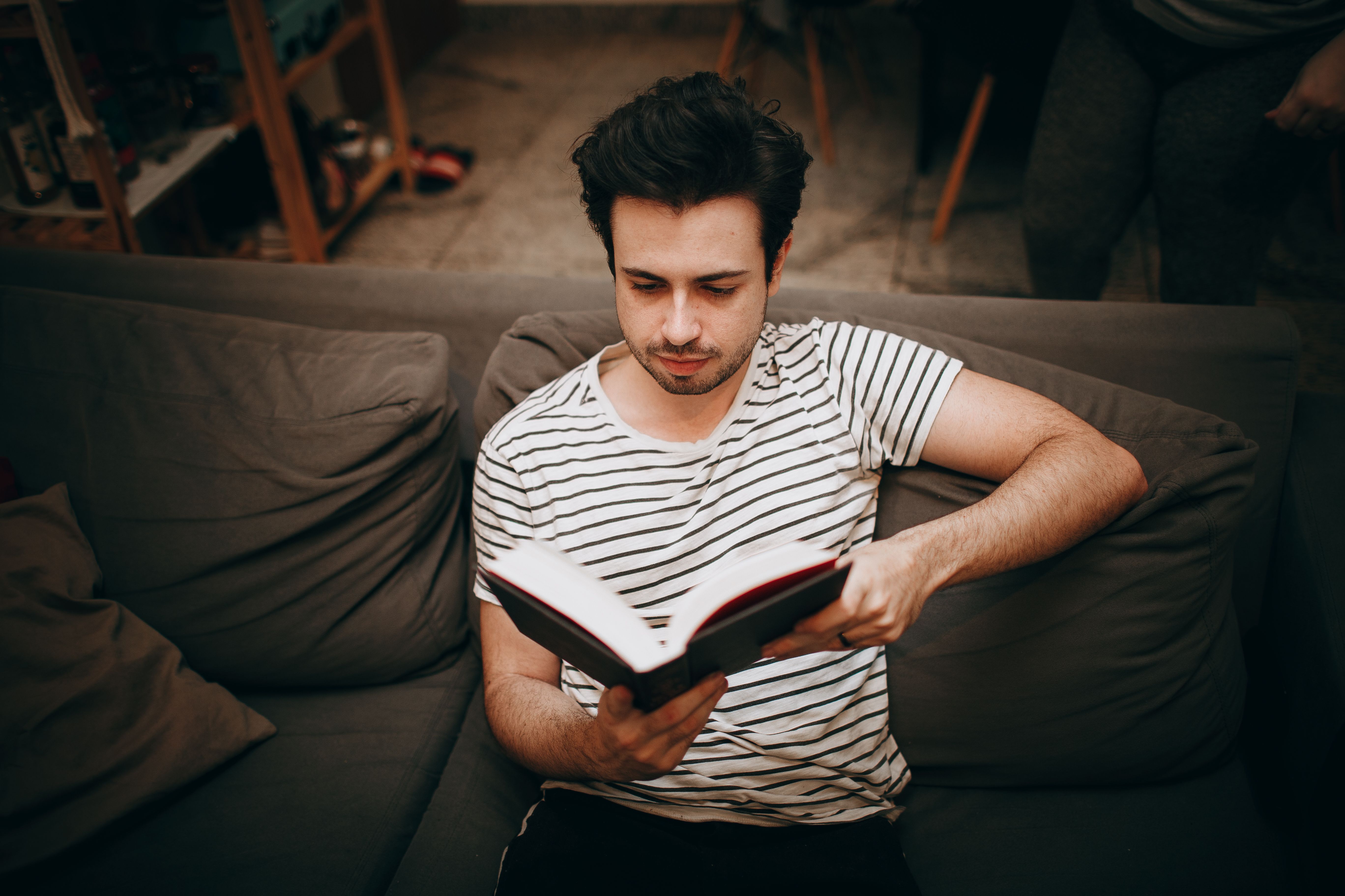 Man Sitting on Couch and Reading Book · Free Stock Photo