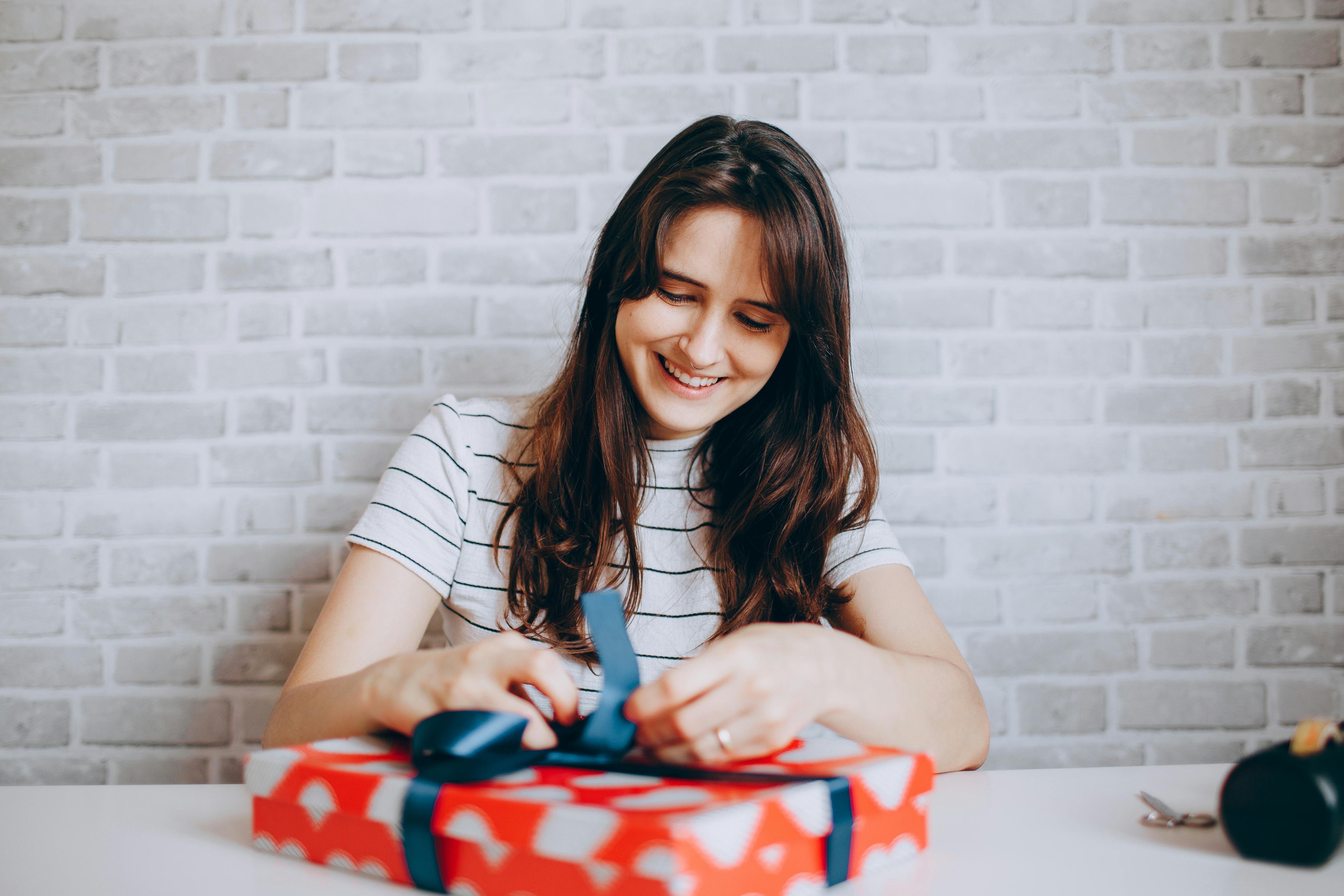 Brunette Woman Opening Present · Free Stock Photo