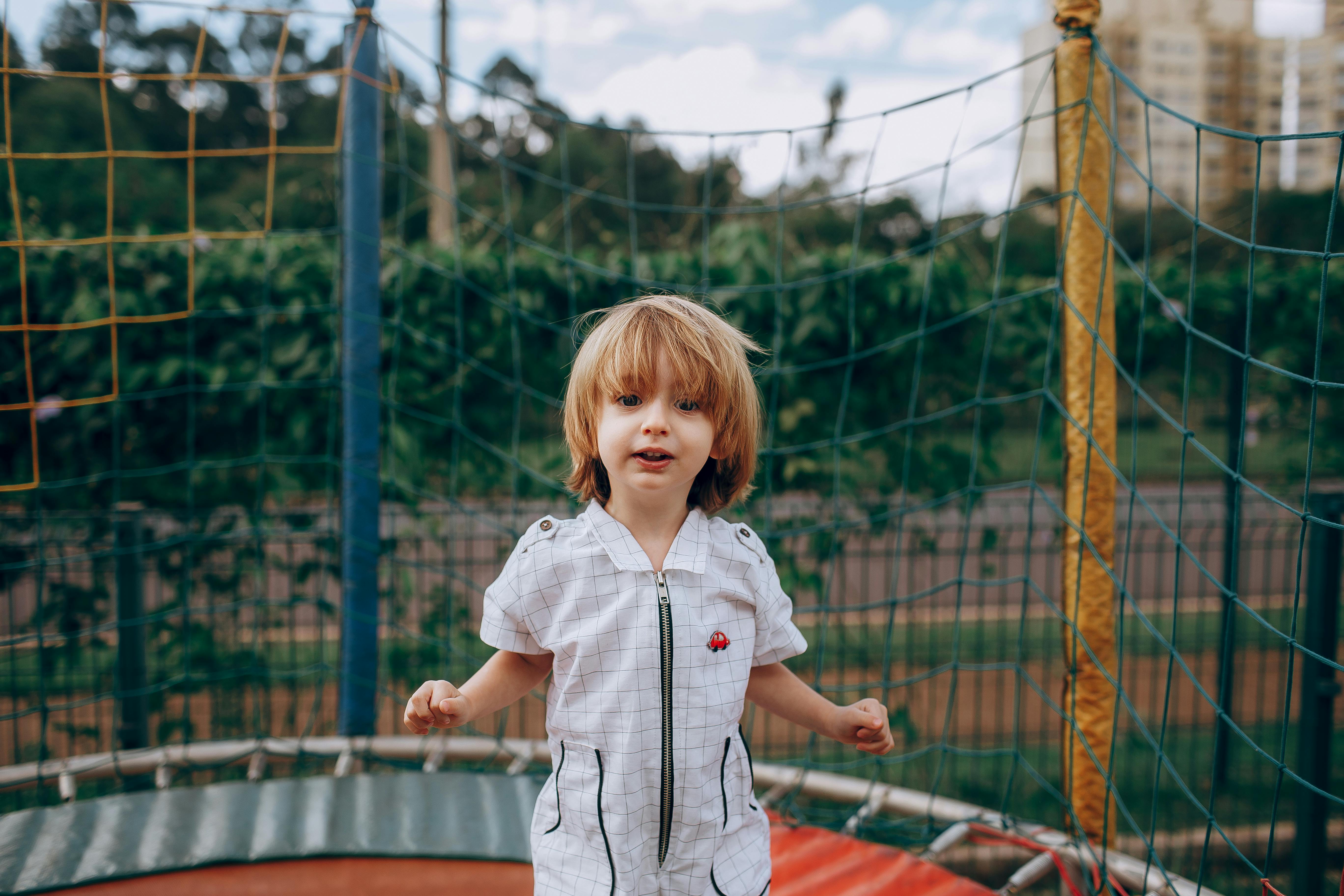 A young boy standing on a trampol · Free Stock Photo