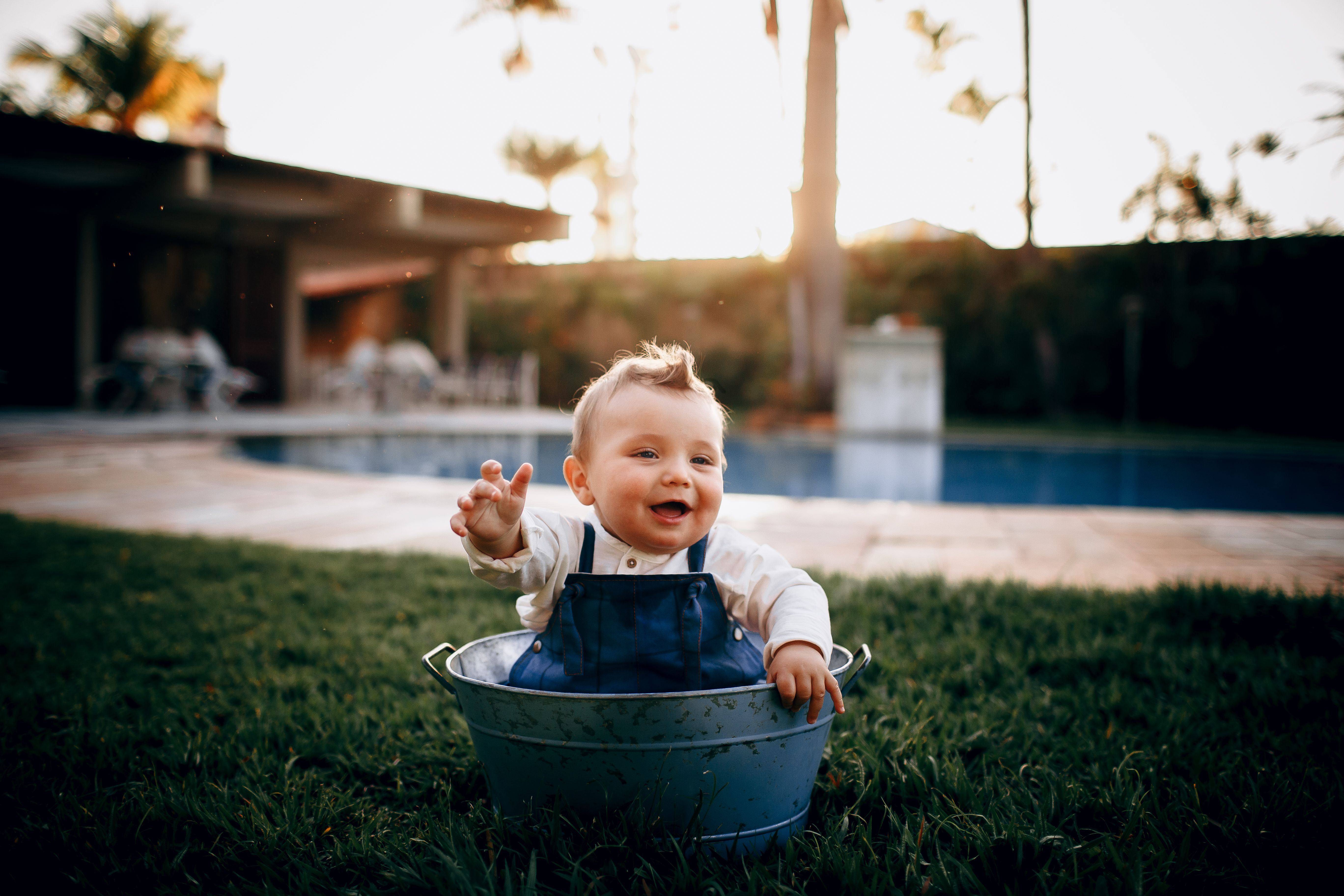 A baby in a bucket by a pool · Free Stock Photo