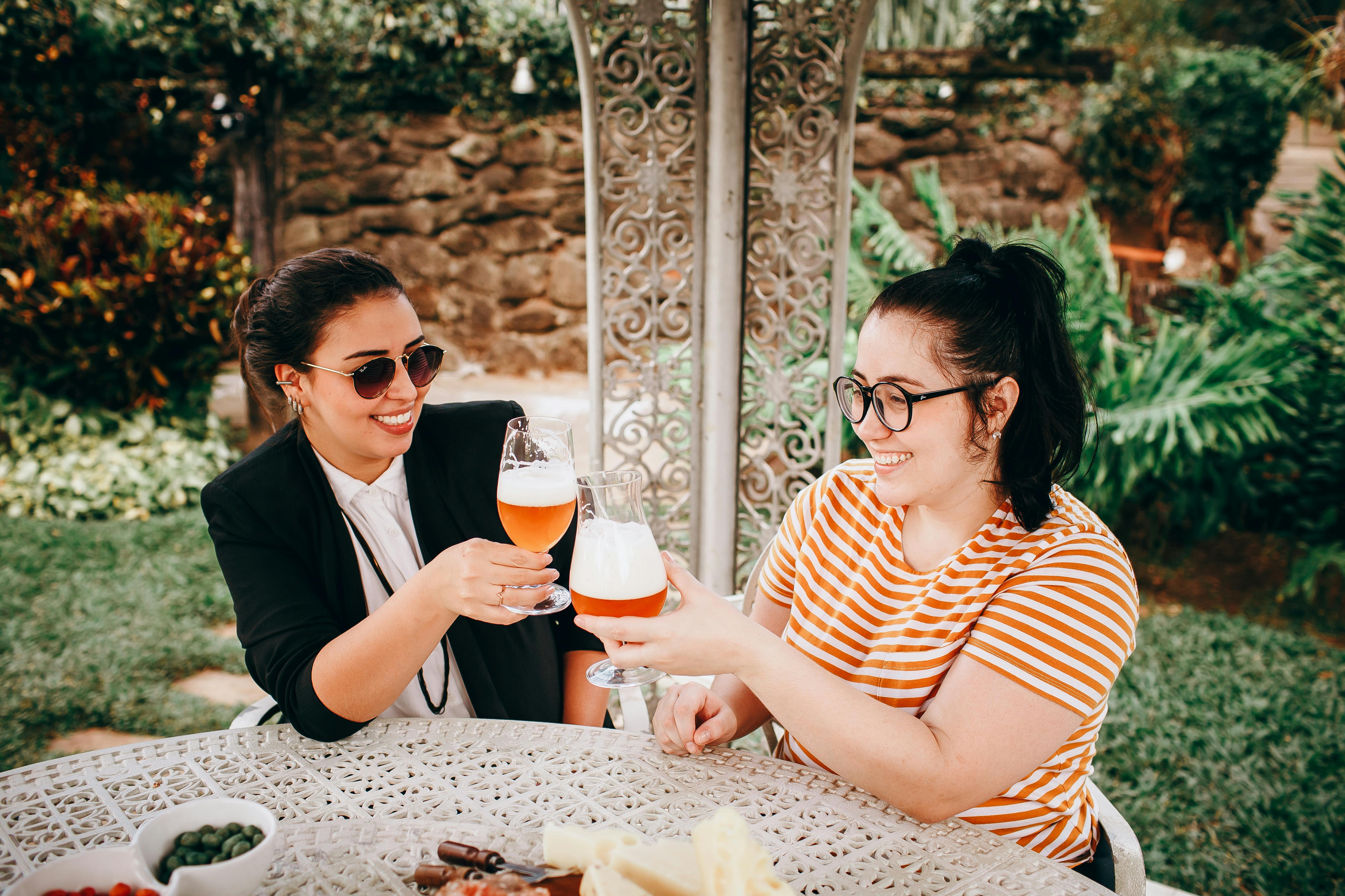 Women Toasting with Cocktails While Sitting at Table in Garden · Free ...