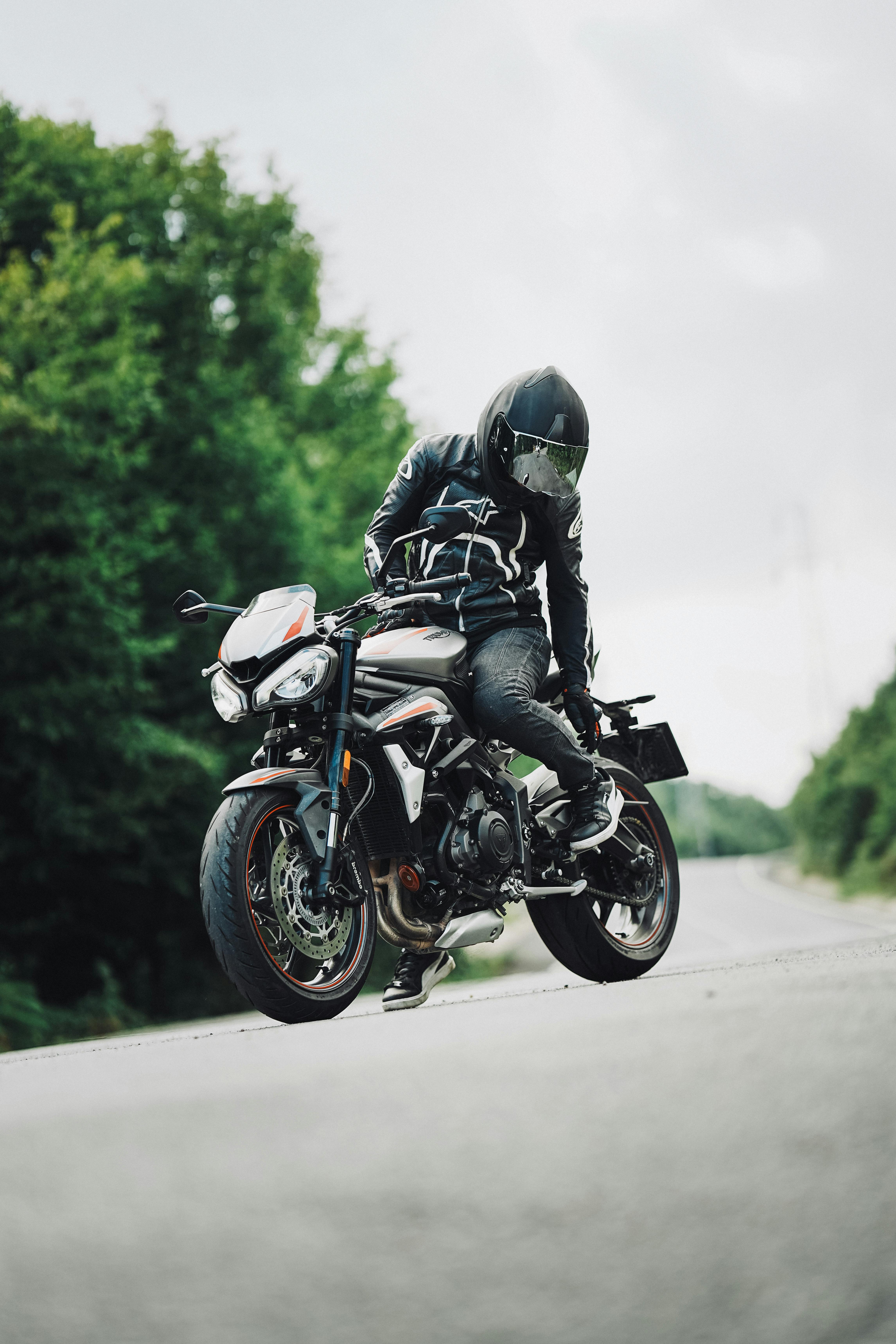Photo of a Motorcyclist Riding a Motorcycle on a Street · Free Stock Photo