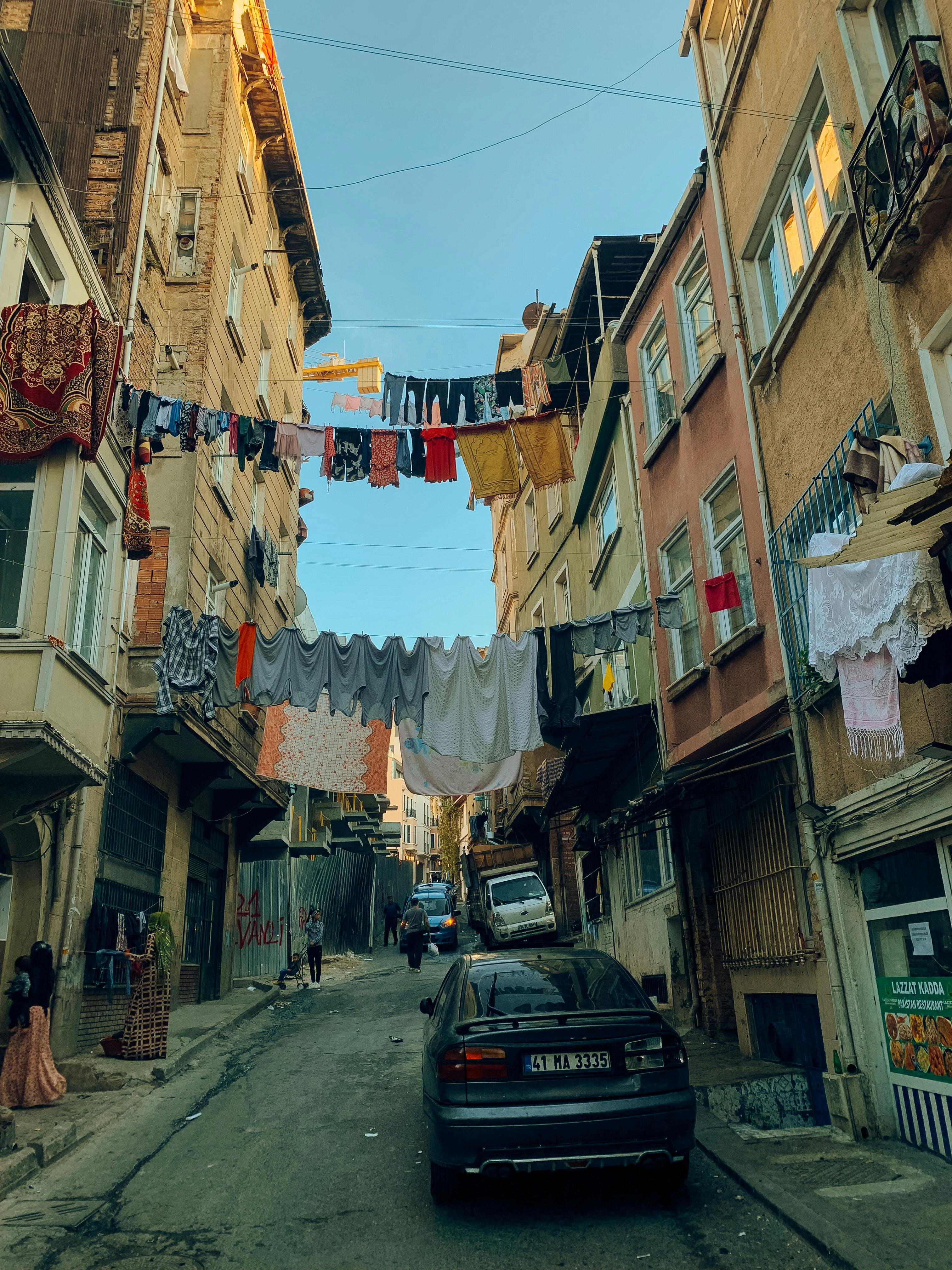 A narrow street with clothes hanging on clotheslines · Free Stock Photo