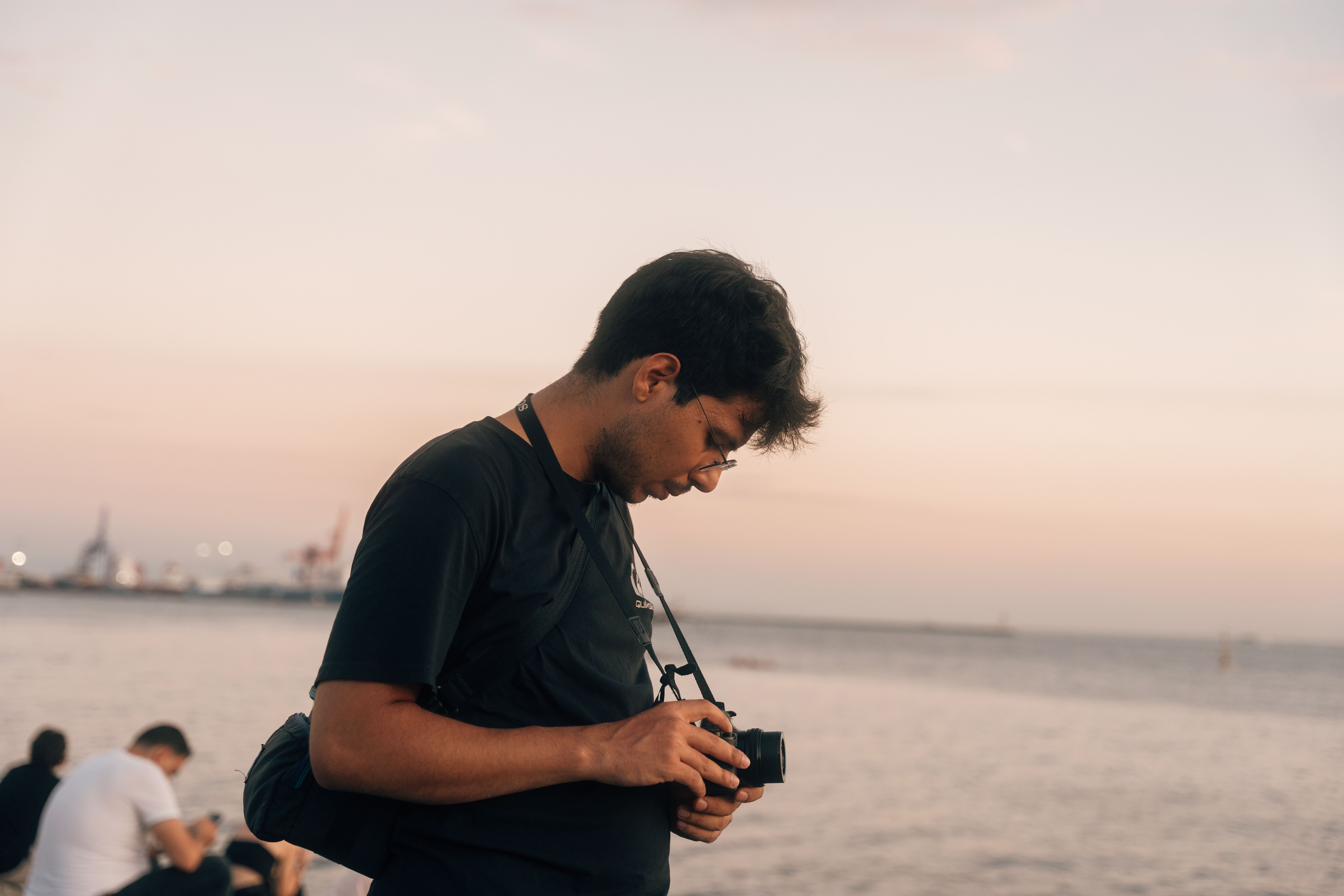 Man Standing with Digital Camera on Seashore · Free Stock Photo