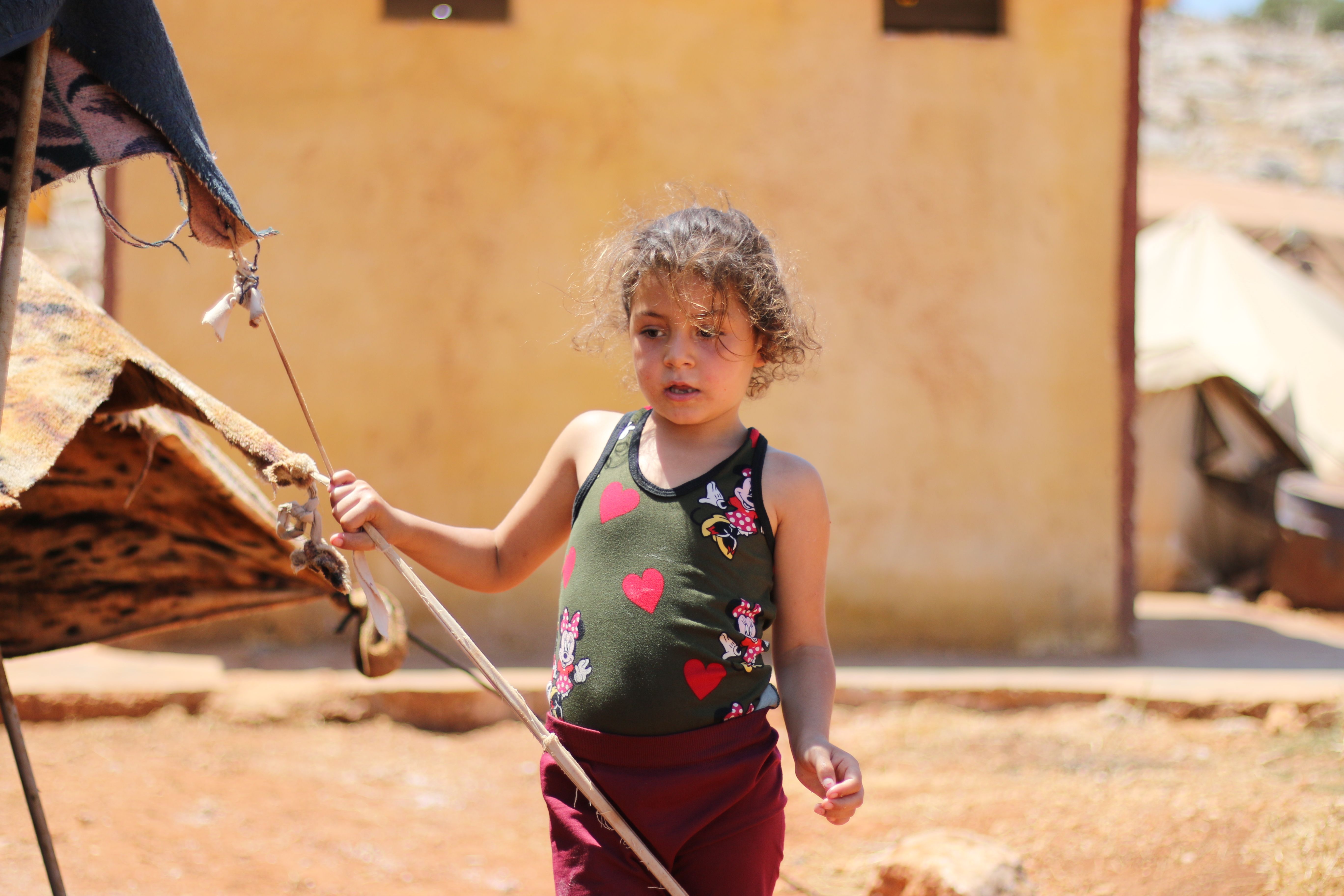 A Little Girl Standing next to a Tent · Free Stock Photo