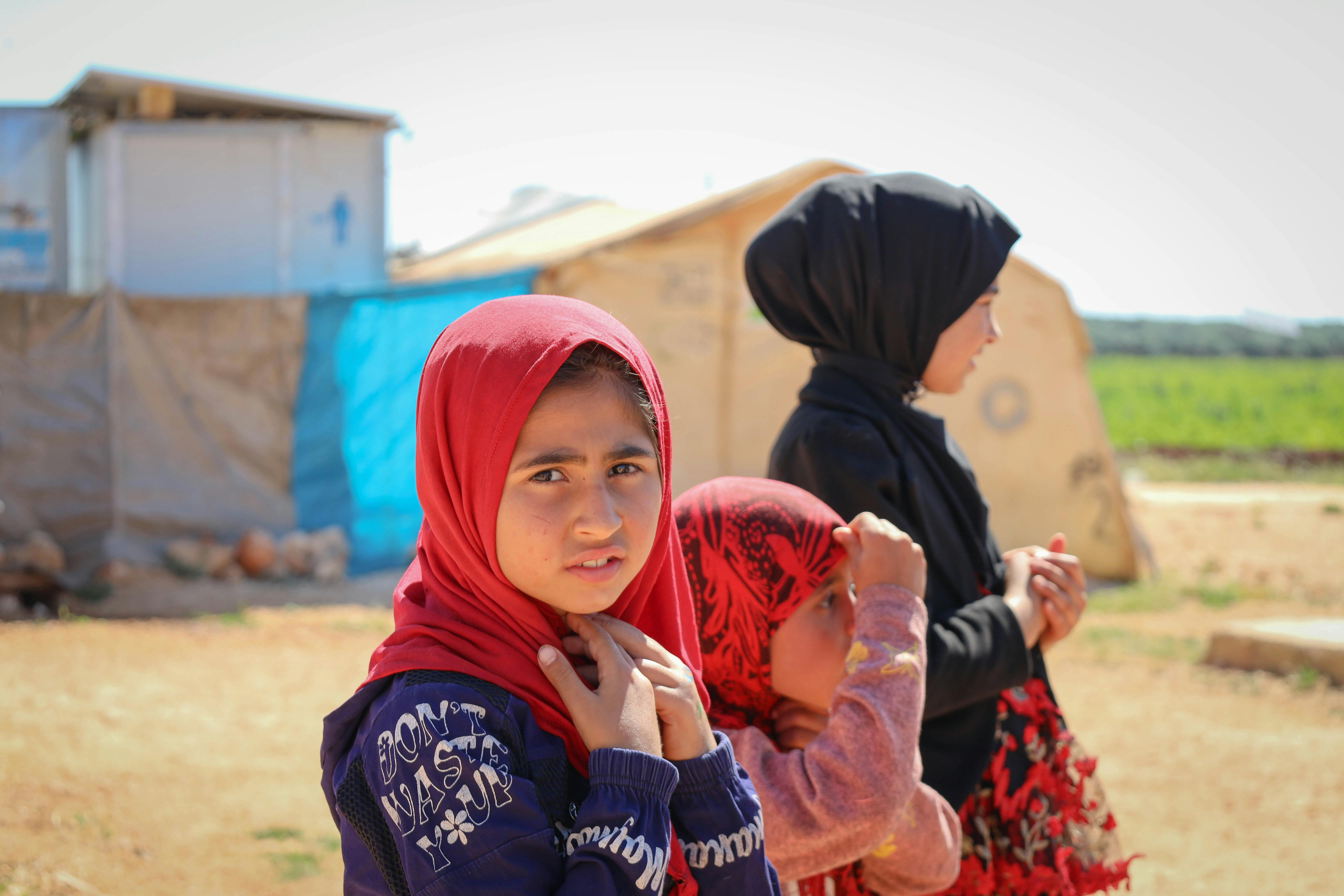 Two young girls in headscarves standing in front of a tent · Free Stock ...