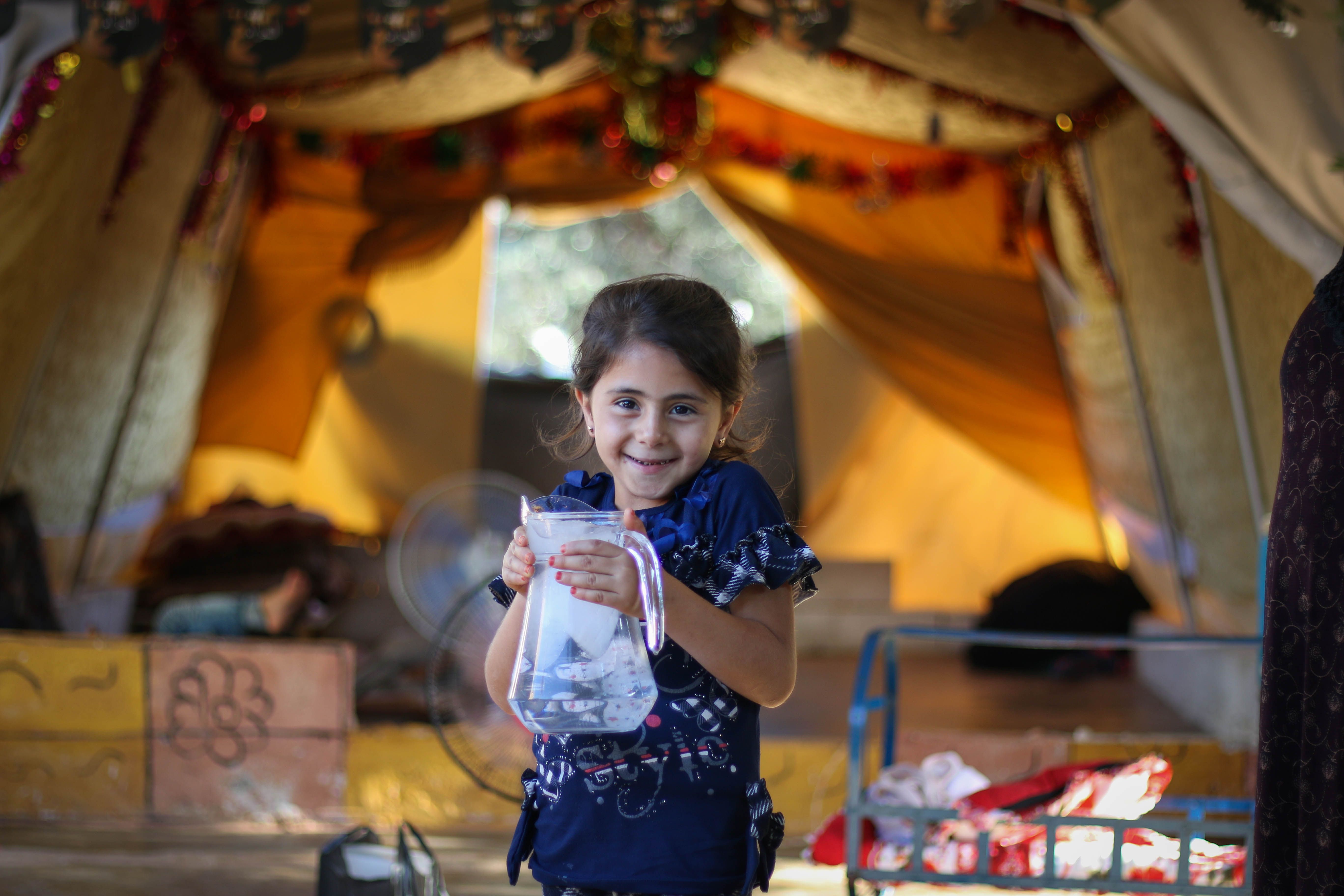 A Little Girl Holding a Glass Jar with Water · Free Stock Photo